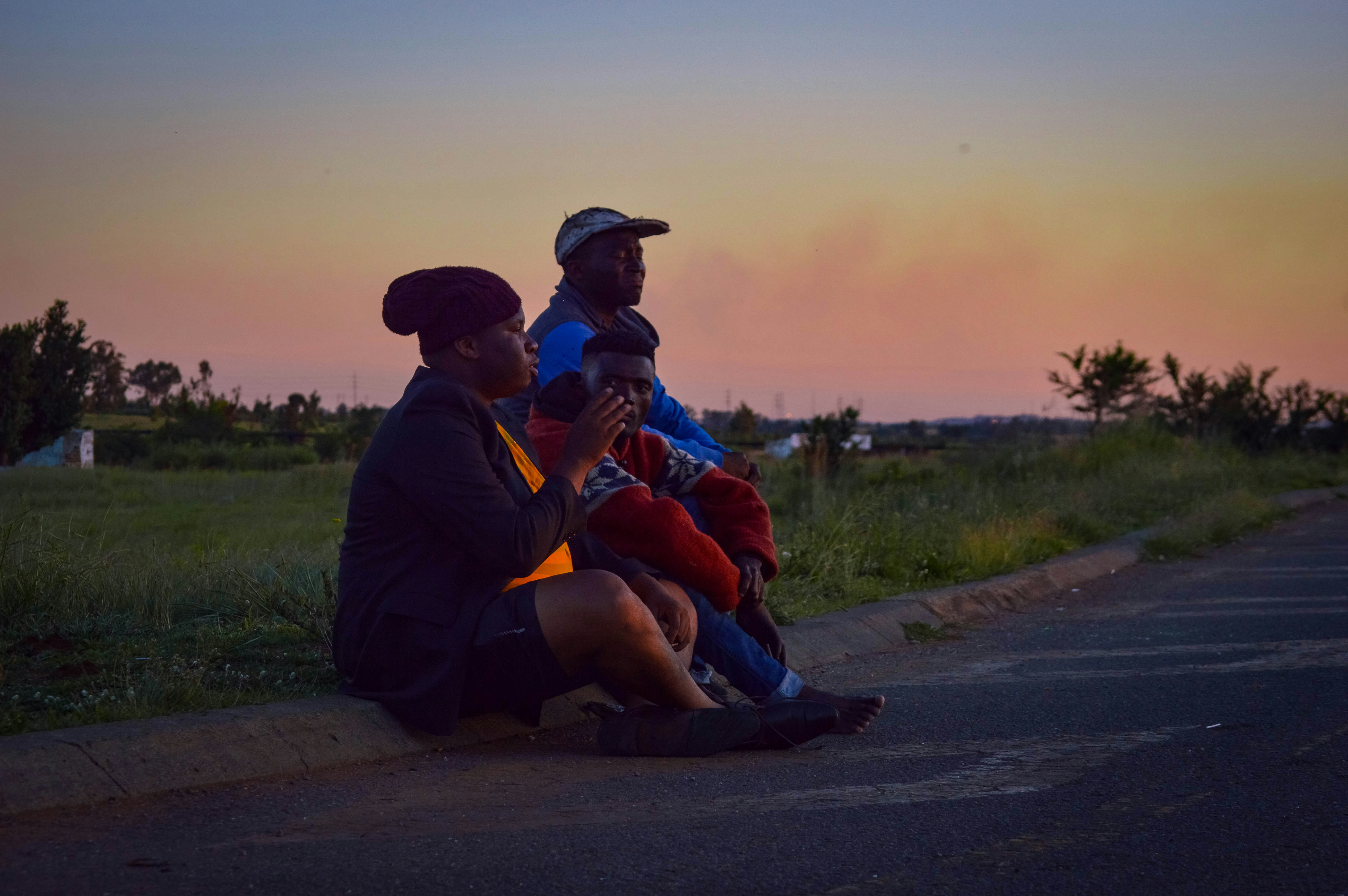 Evening on the curb: a family gathered in quiet anticipation