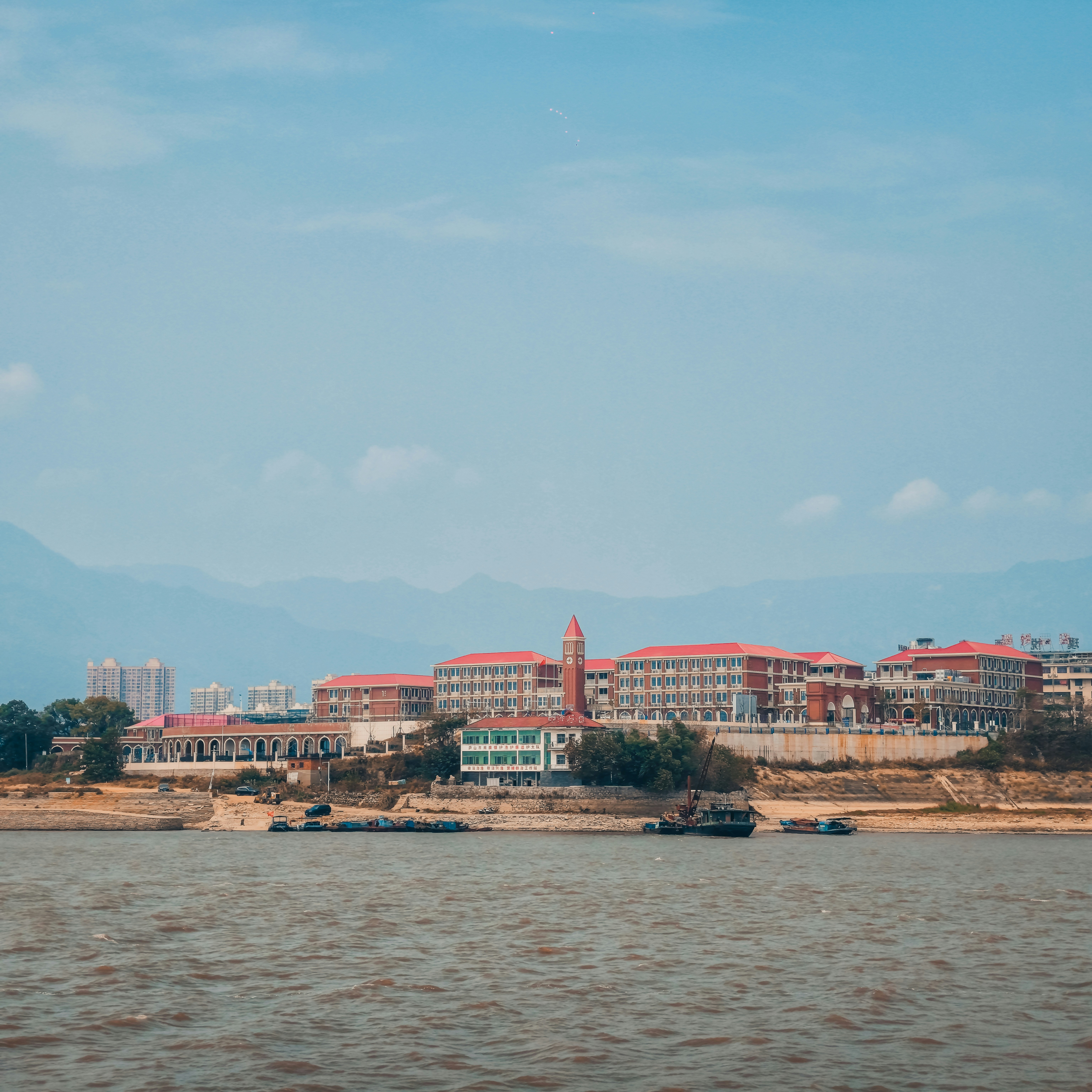 Riverfront Retreat: Boats, Architecture, and Distant Mountains