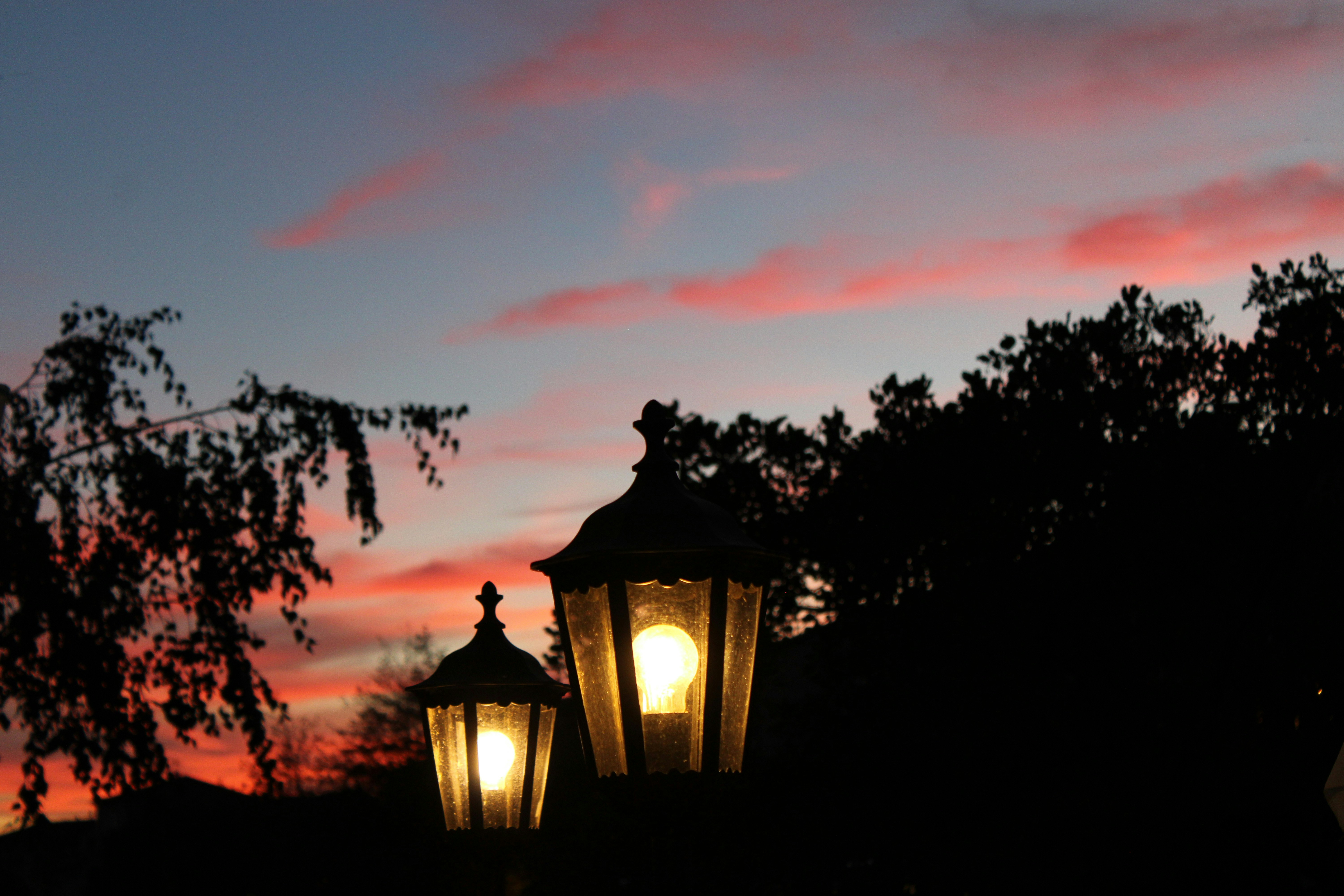 Glow on the Gables: Evening Lamps Against a Sunset Silhouette