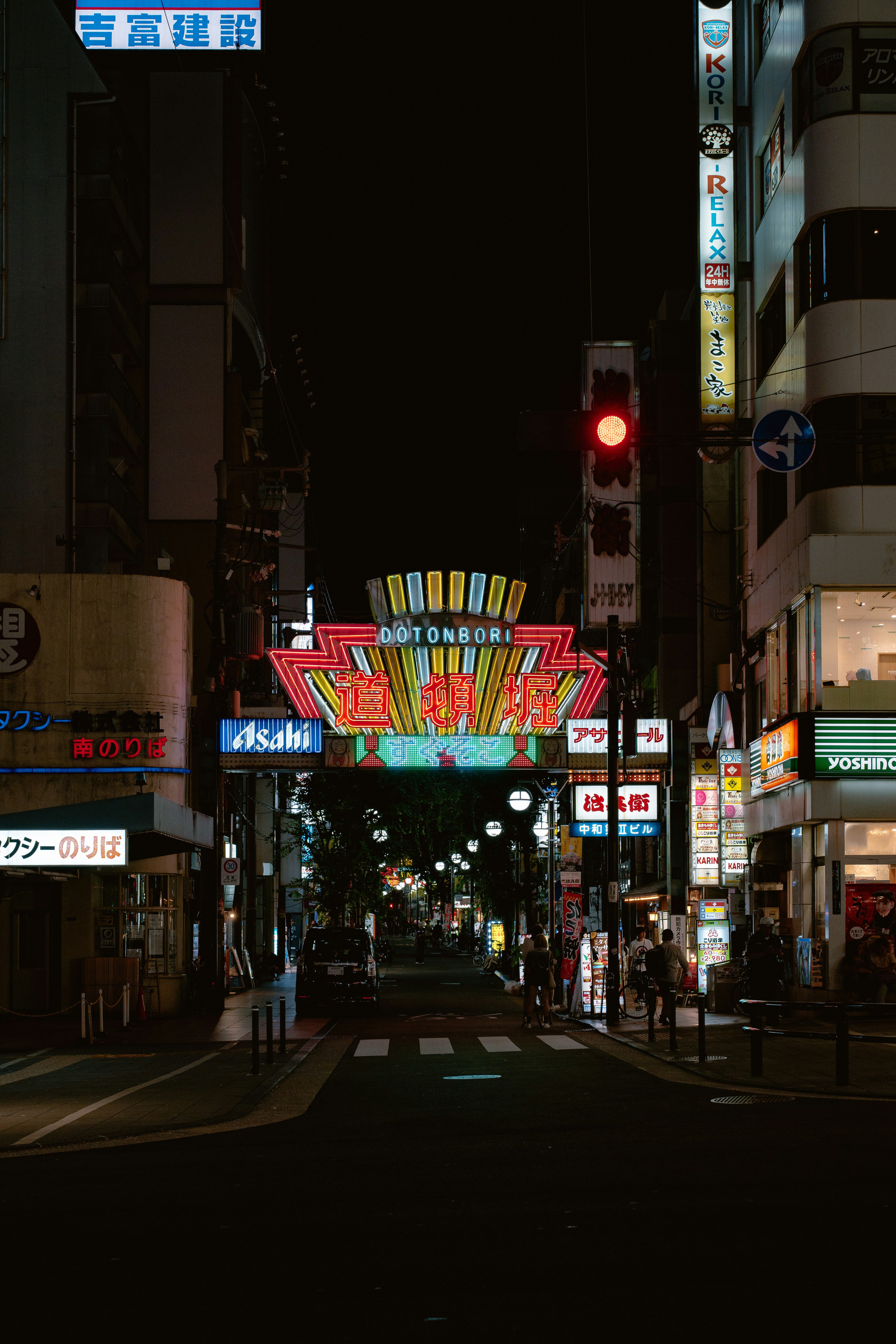 A neon sign reading Dotonbori above a quiet street in Osaka at night