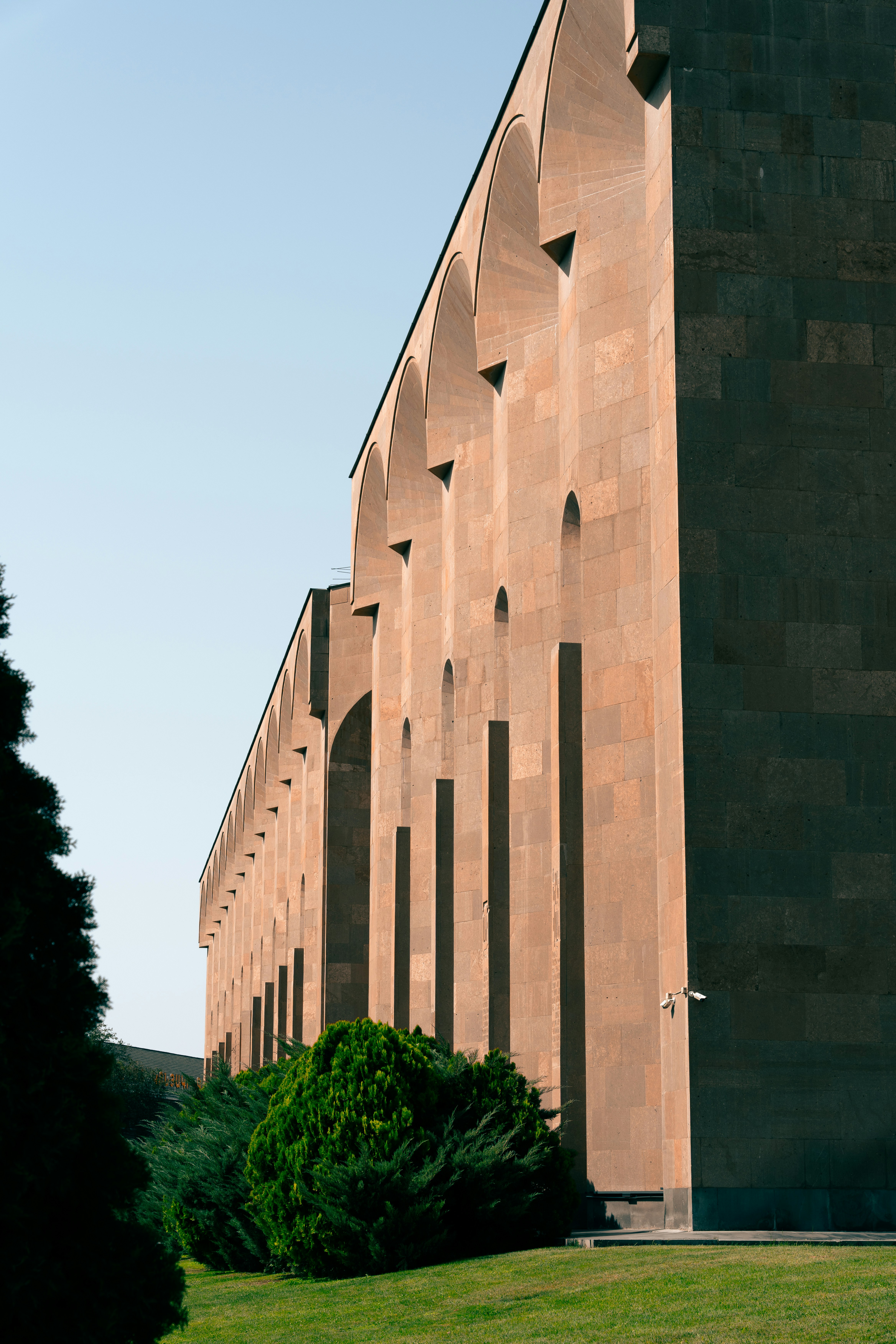 Stone Archway Corridor: A Monumental Wall Reaches Toward a Clear Sky
