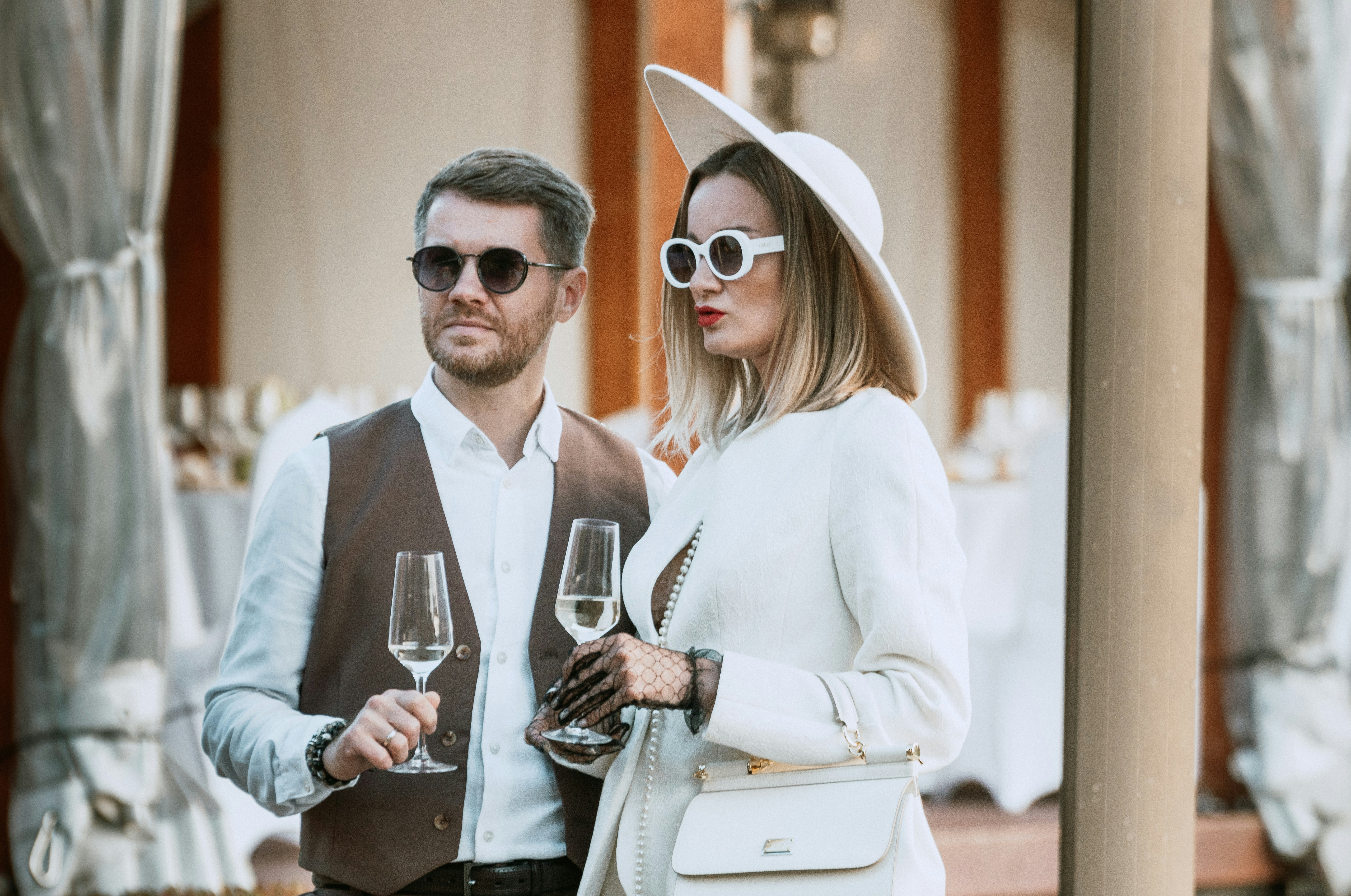Elegant toast under warm chandeliers: a mid-shot of a stylish couple