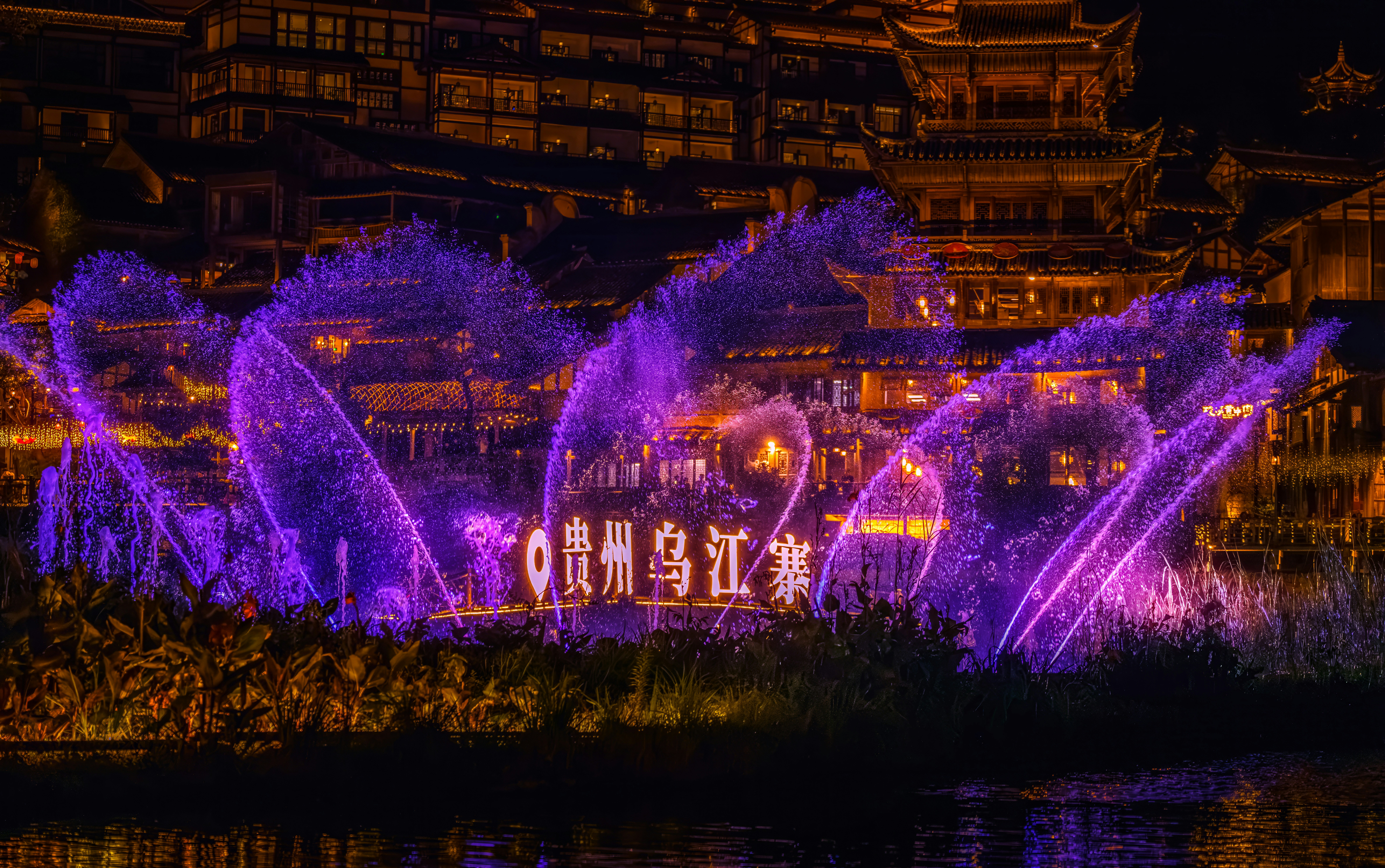 Neon Cascade: Purple Fountain Lights Over a Historic Nightscape