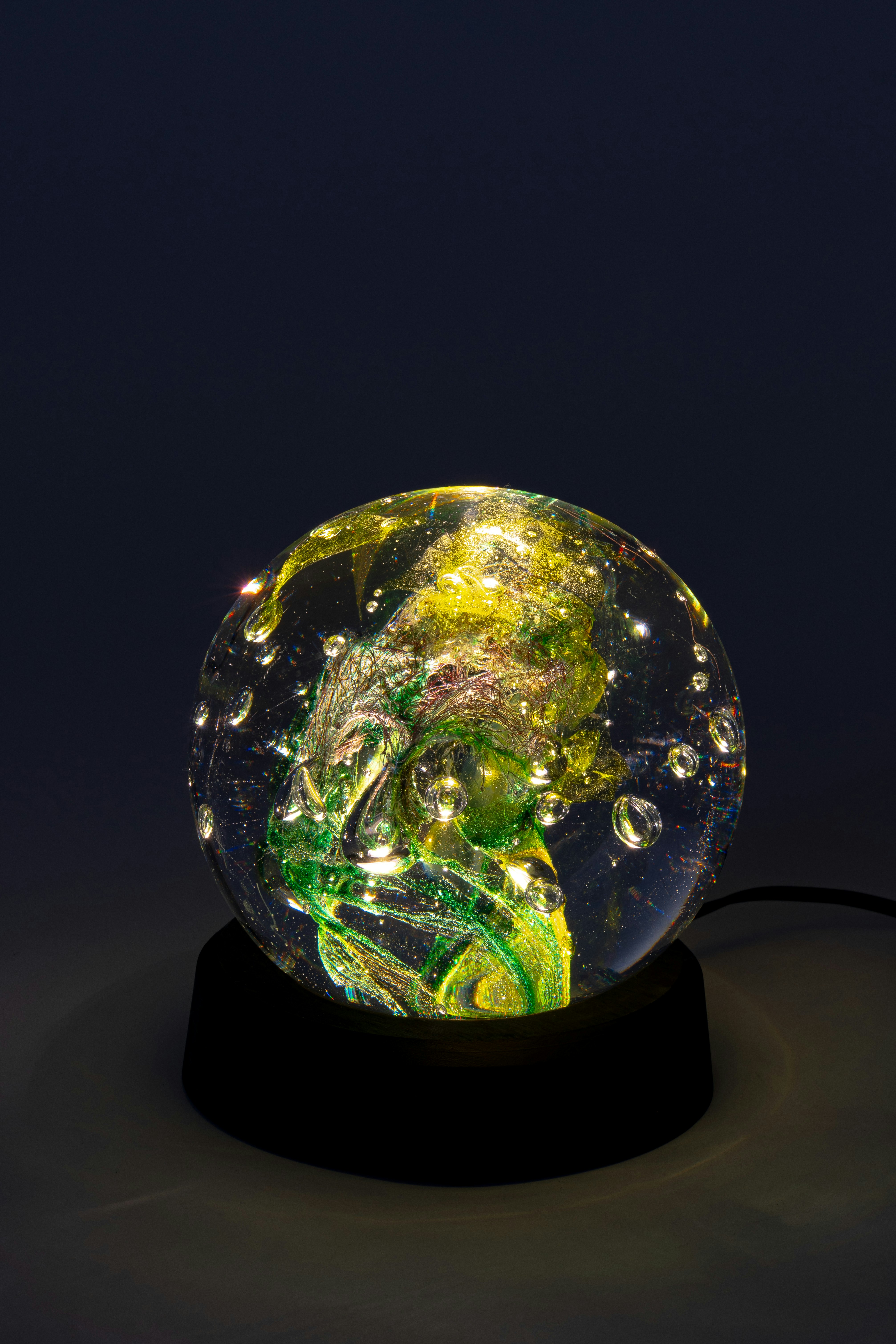Glowing Orb: A Glass Sphere of Green Light on a Soft Spotlight
