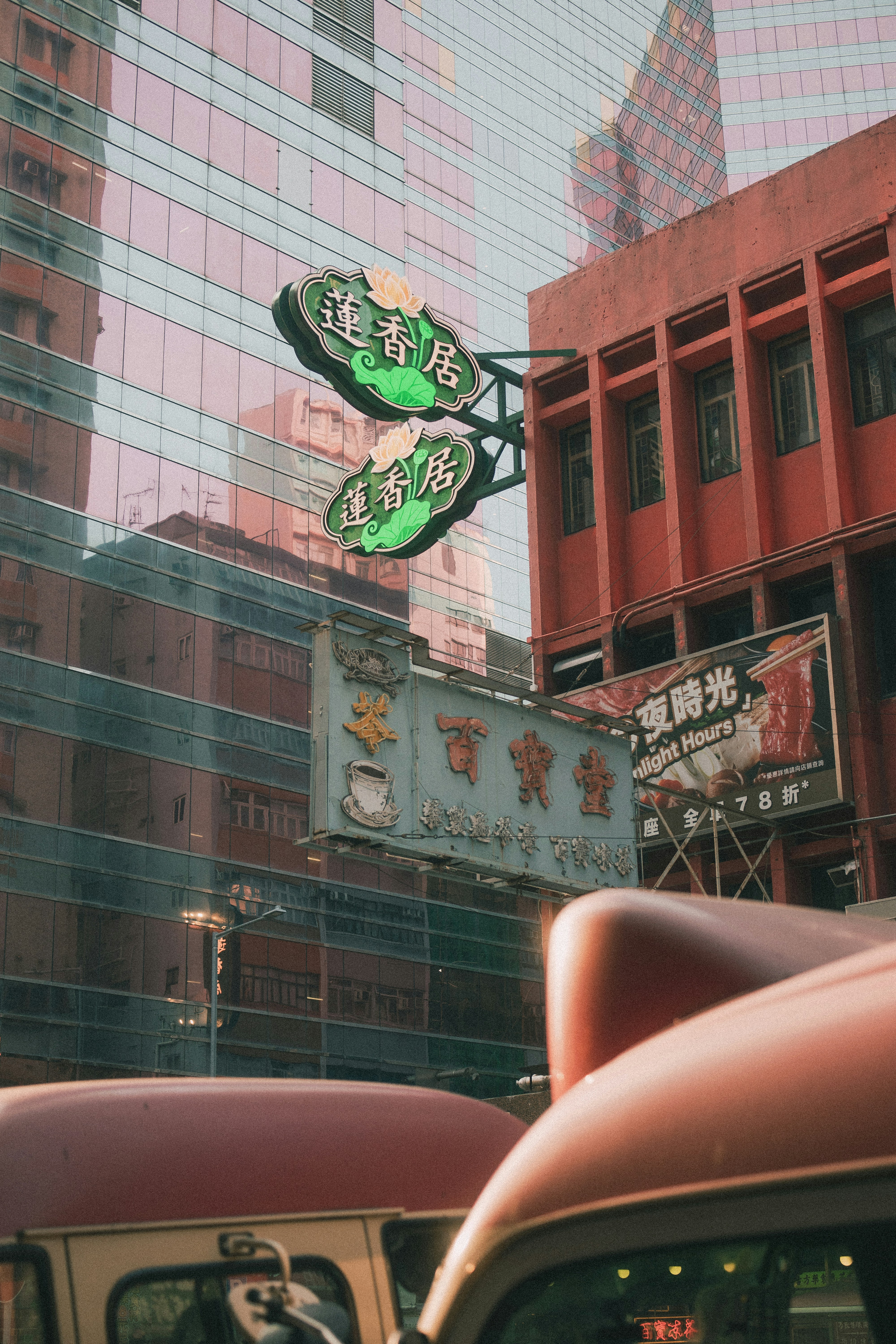 Neon Signage Amid Glass Facades in a Busy Street