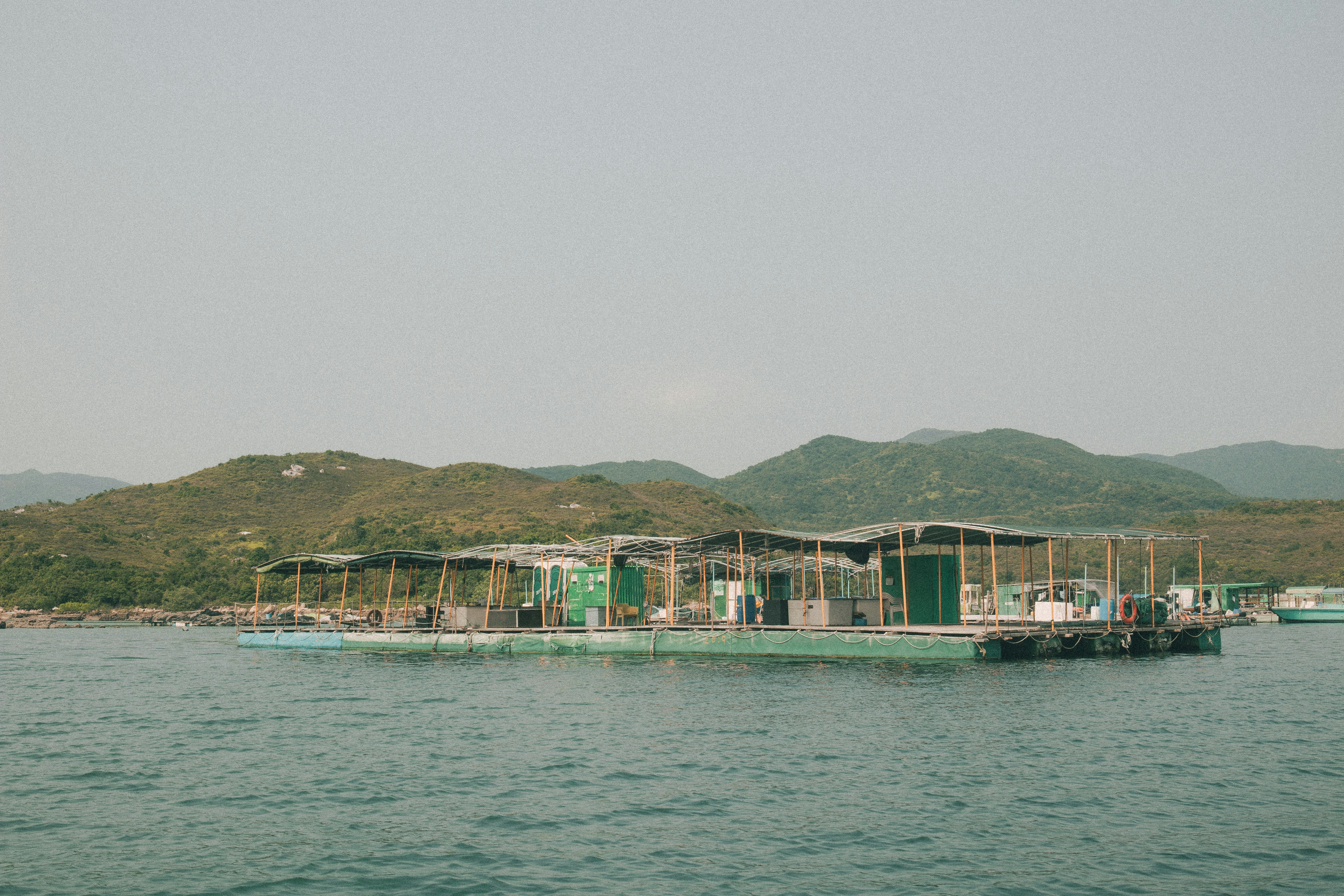 Floating village on calm turquoise waters beneath arid hills