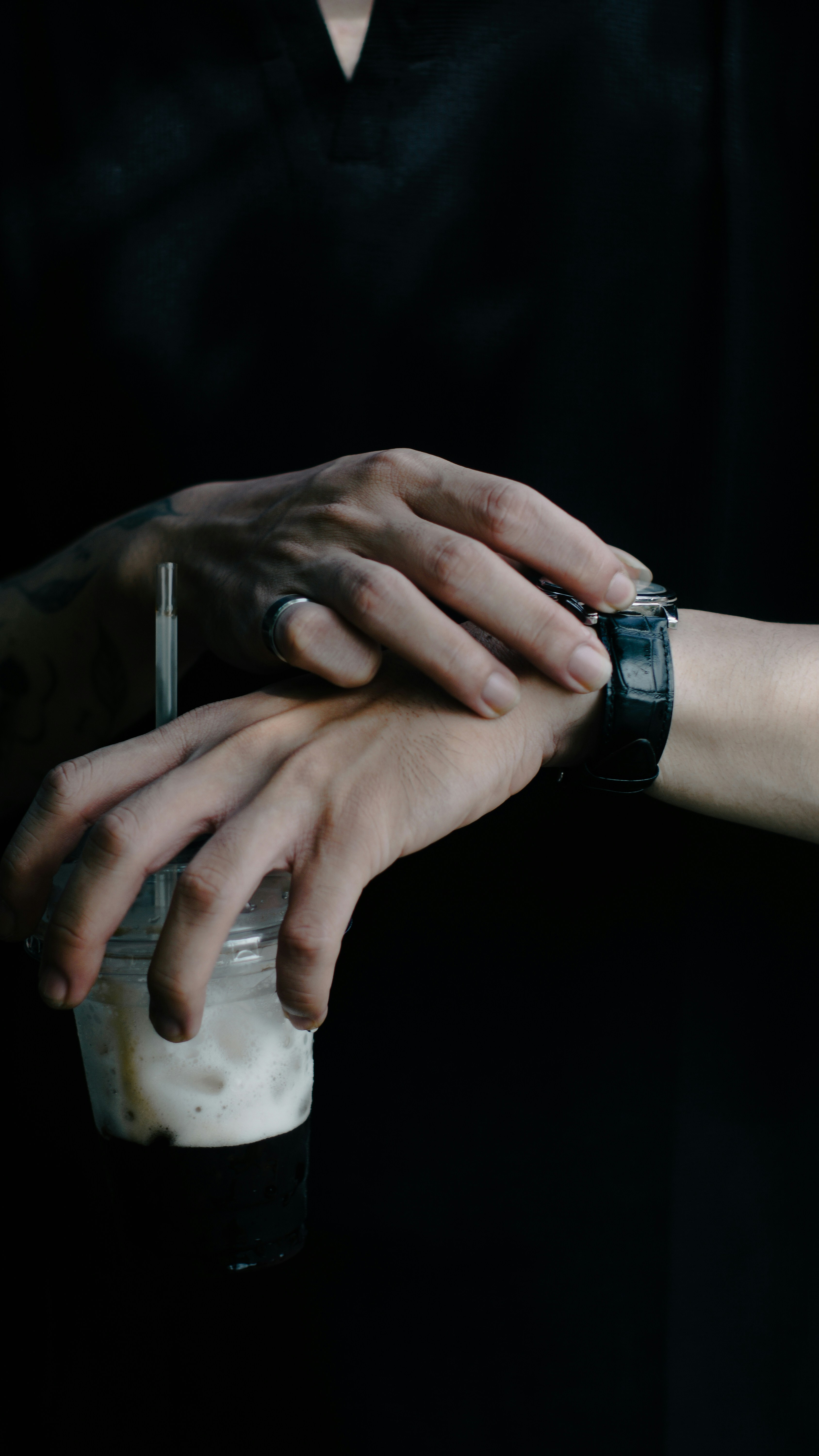 Hands on a chilled moment: a glass of iced coffee held steady