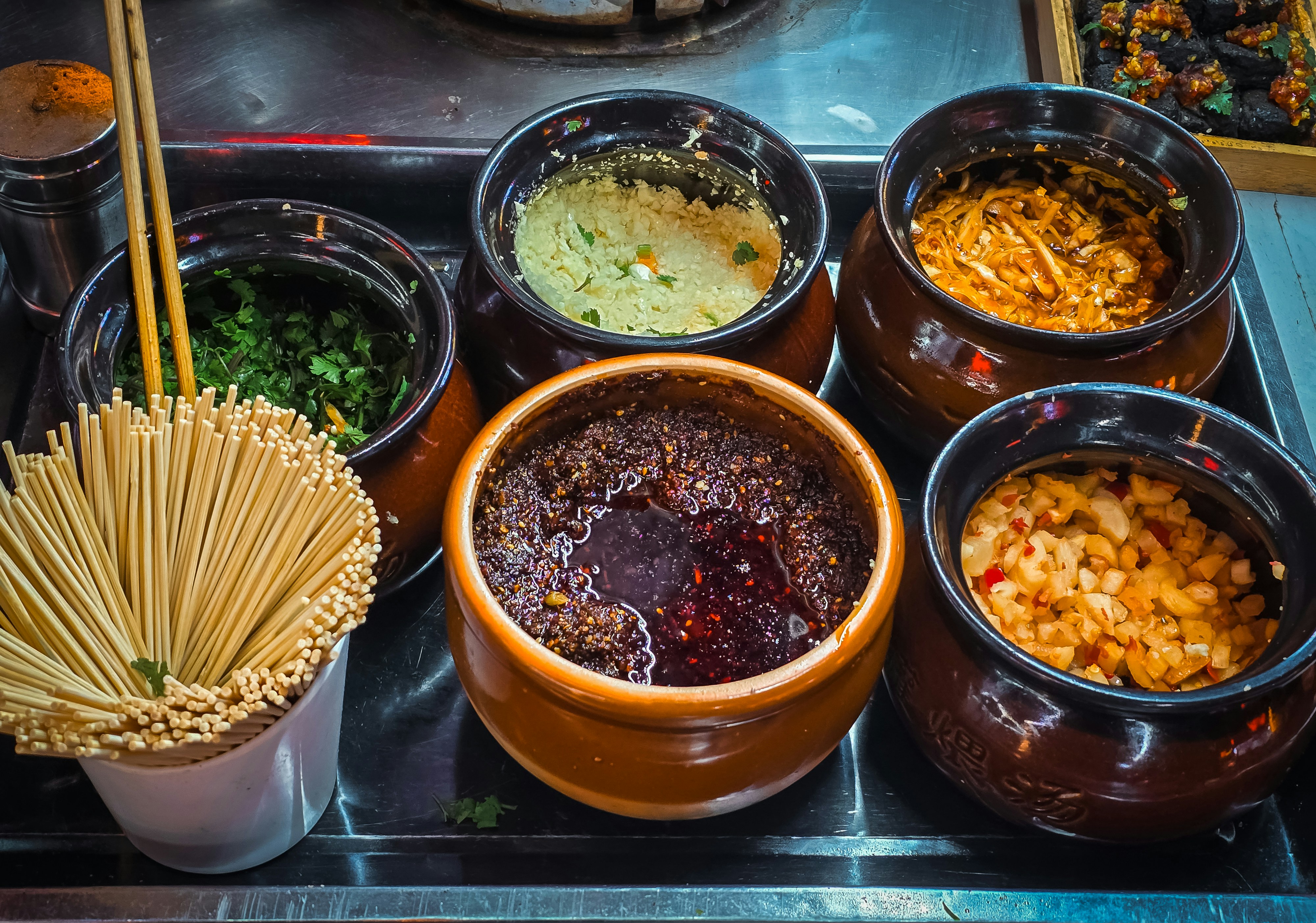 Five Clay Pot Sauces: A Tangy Array Beneath a Tangle of Sticks