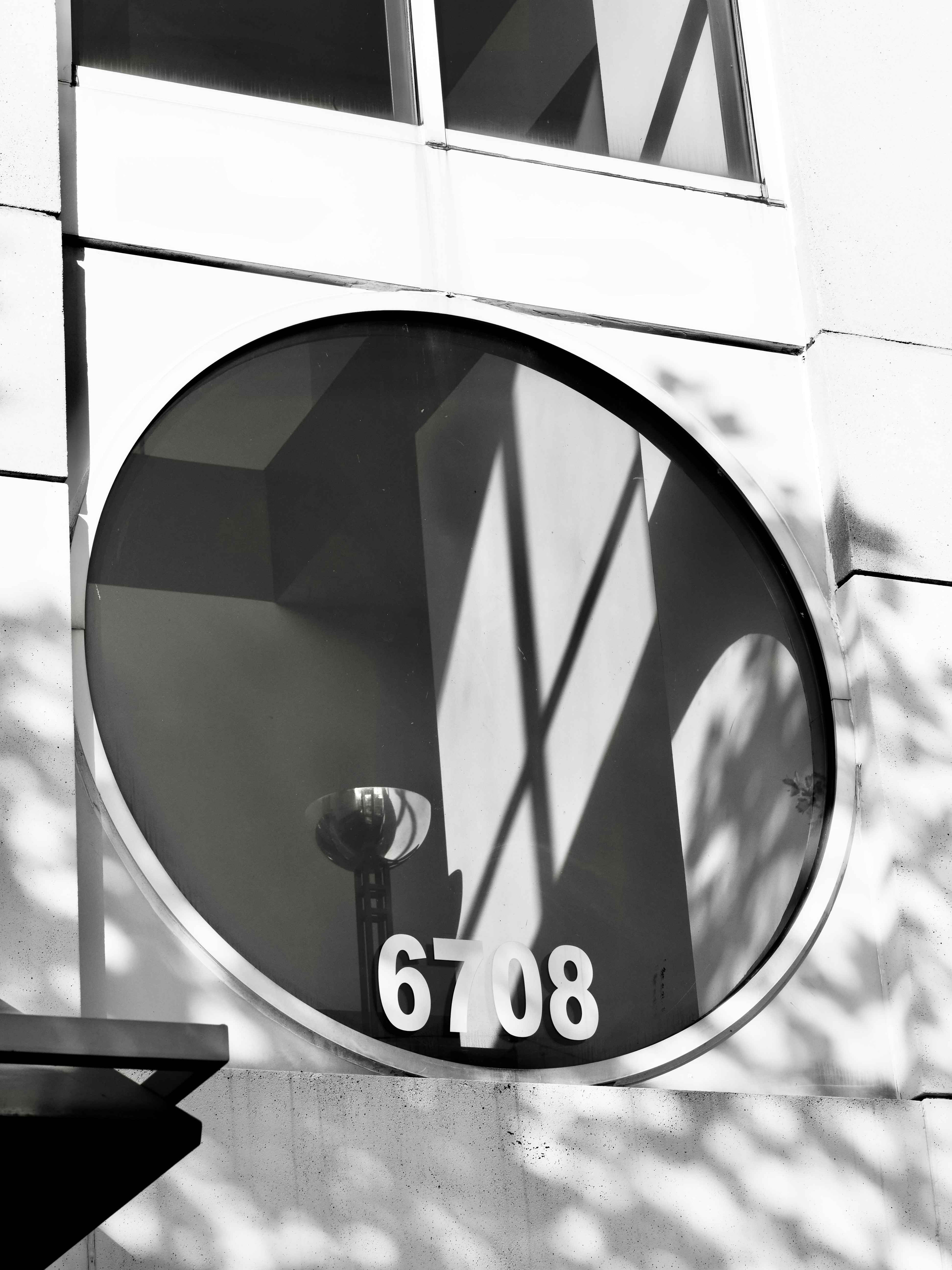 Circle of Light and Numbers: Architectural Window in Sunlit Monochrome