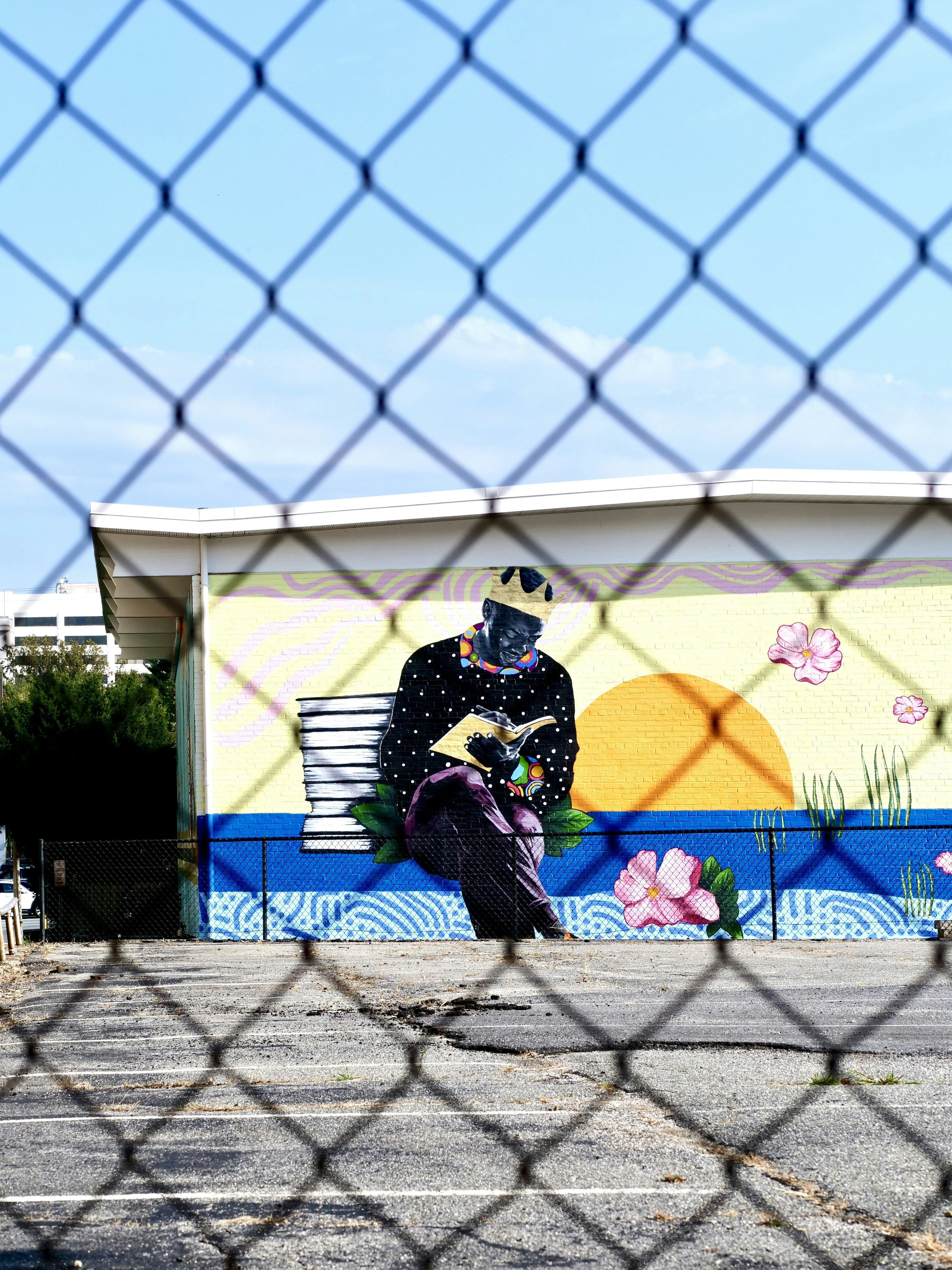 Graffiti Seer: A Figure Reading Under a Painted Sun