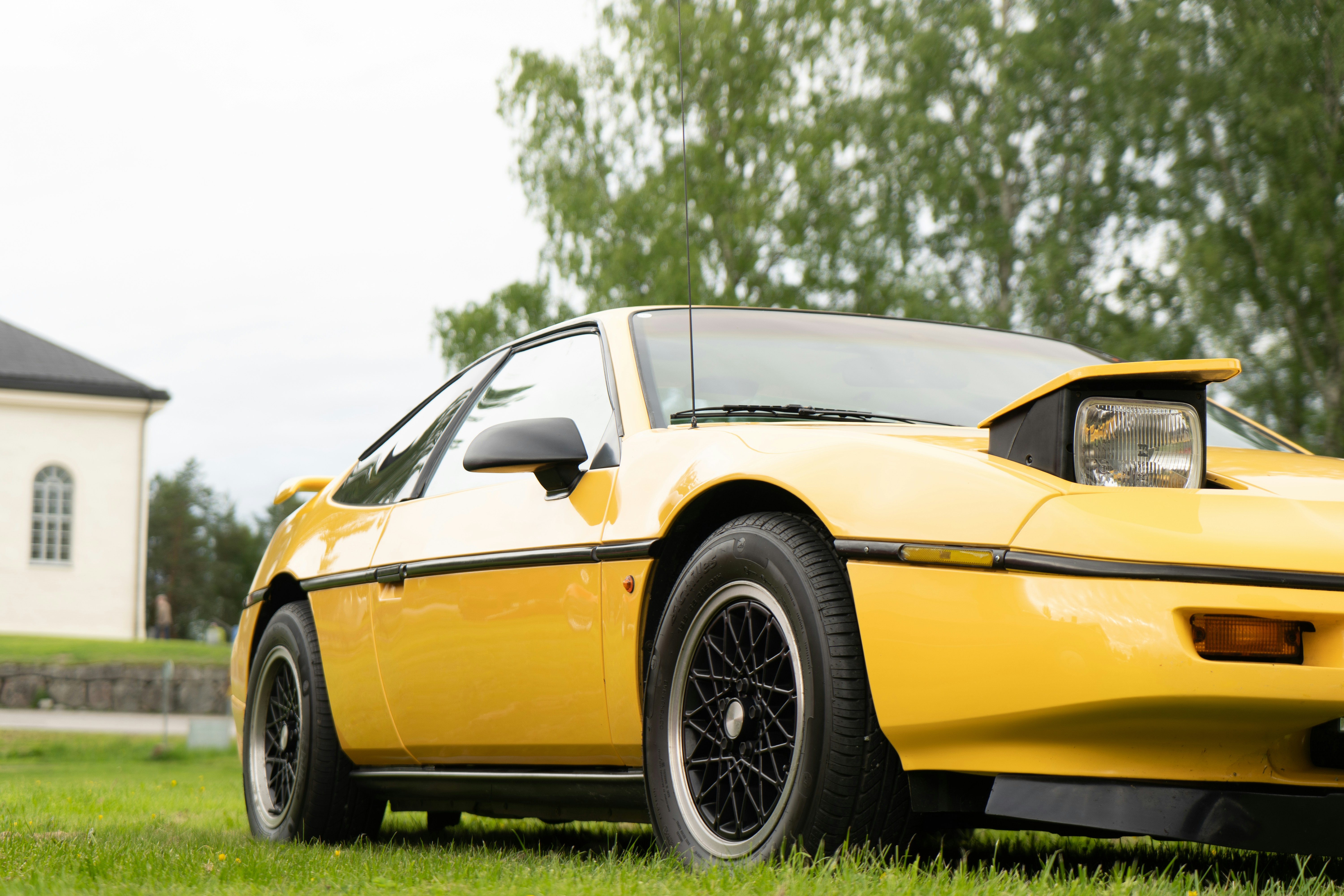 A Yellow Phantom: Classic Sports Car Resting on the Glistening Green