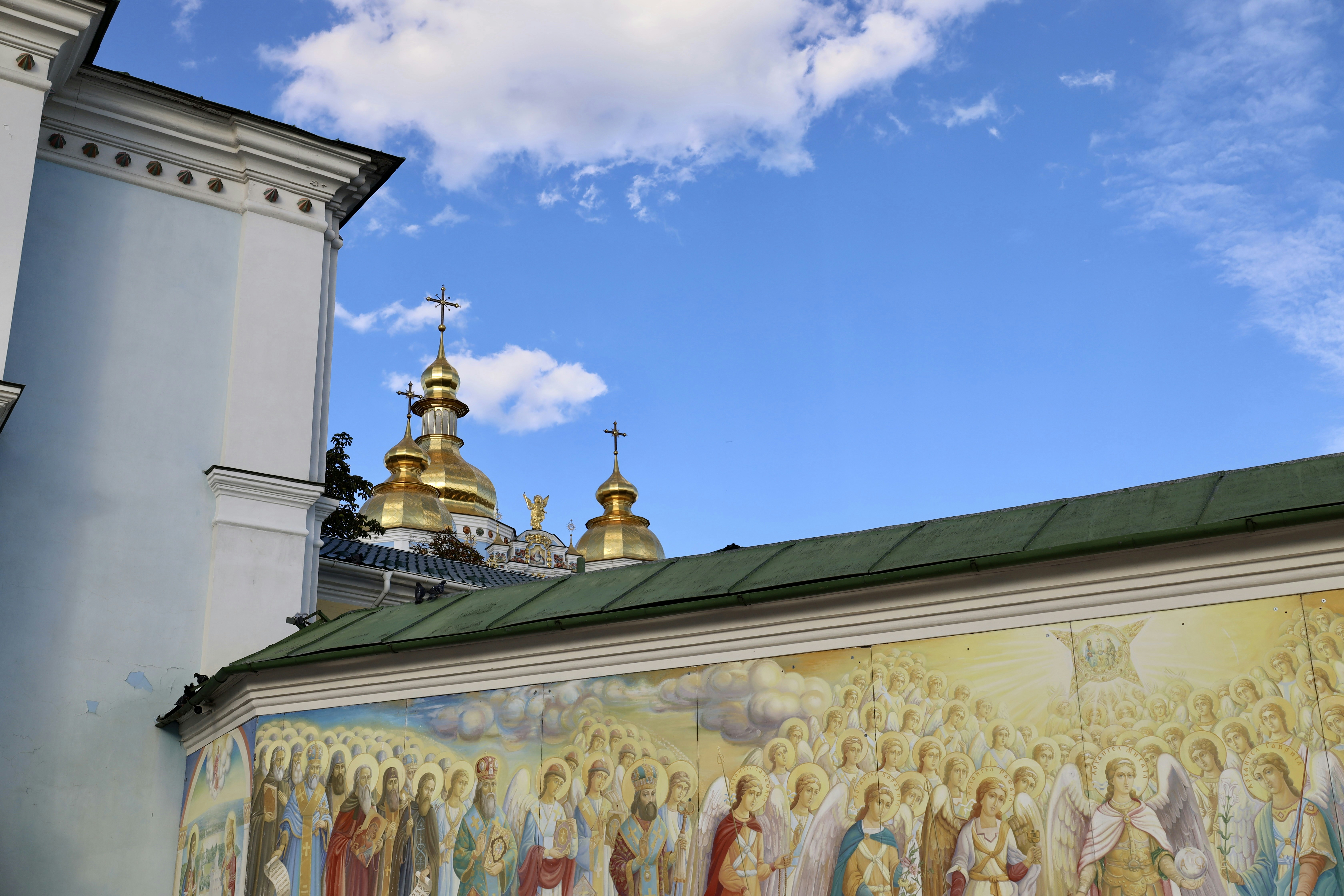 Golden Cupolas Against a Clear Sky Over a Painted Wall