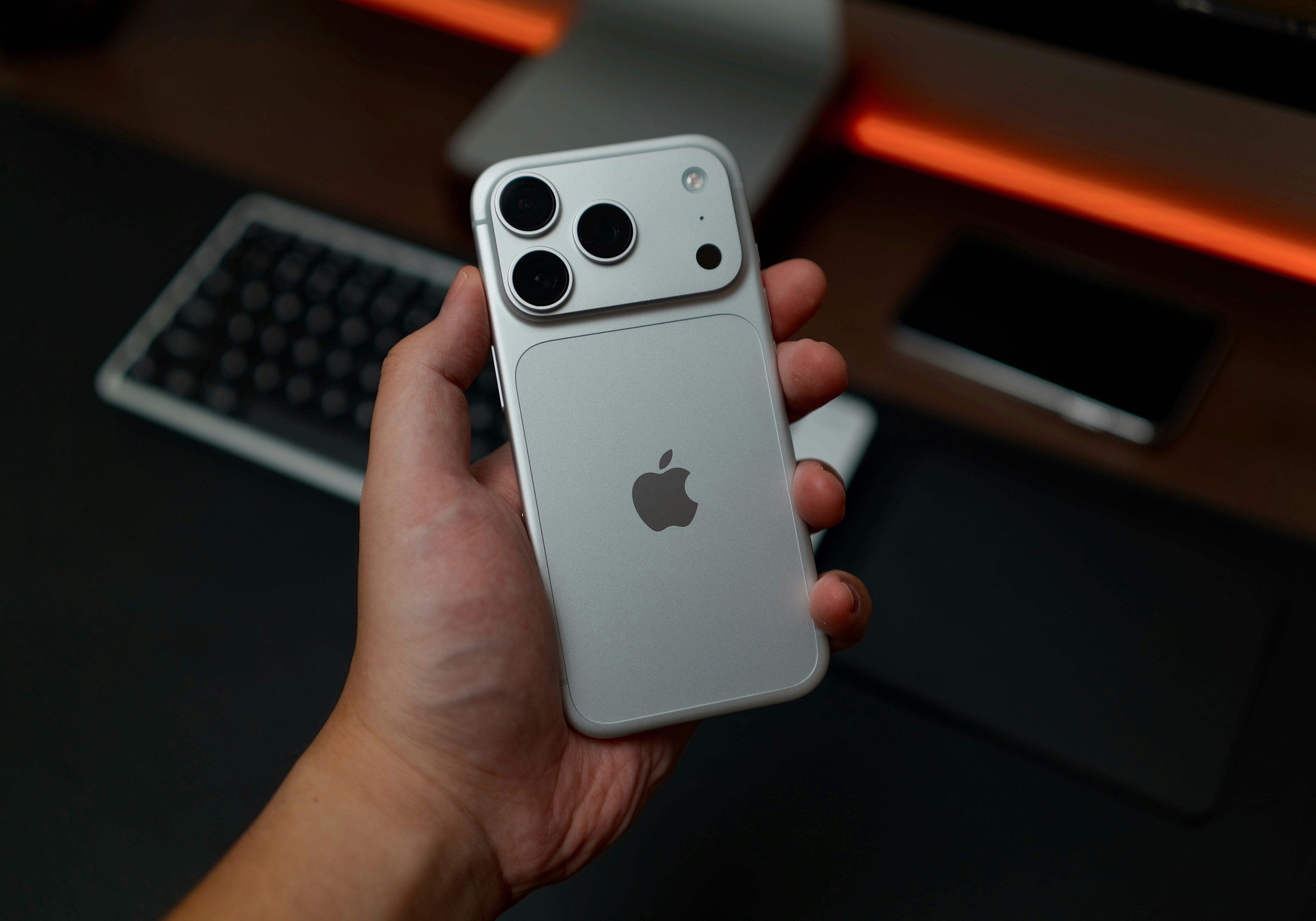 Holding the Apple: A Sleek Propped Phone in a Quiet Tech Studio