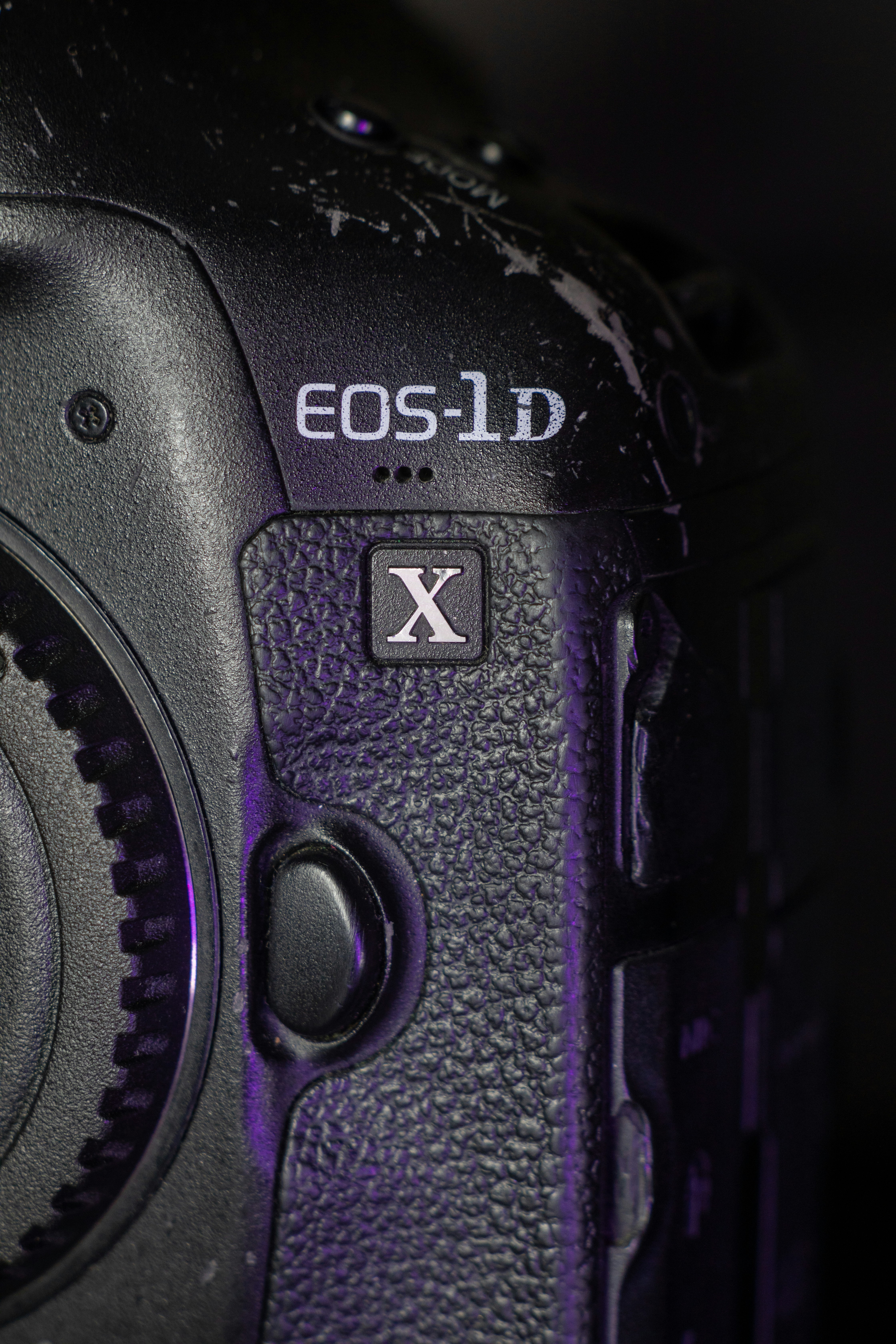 Close-up on a weathered Canon EOS-1D X body leaf with visible logo and textured grip