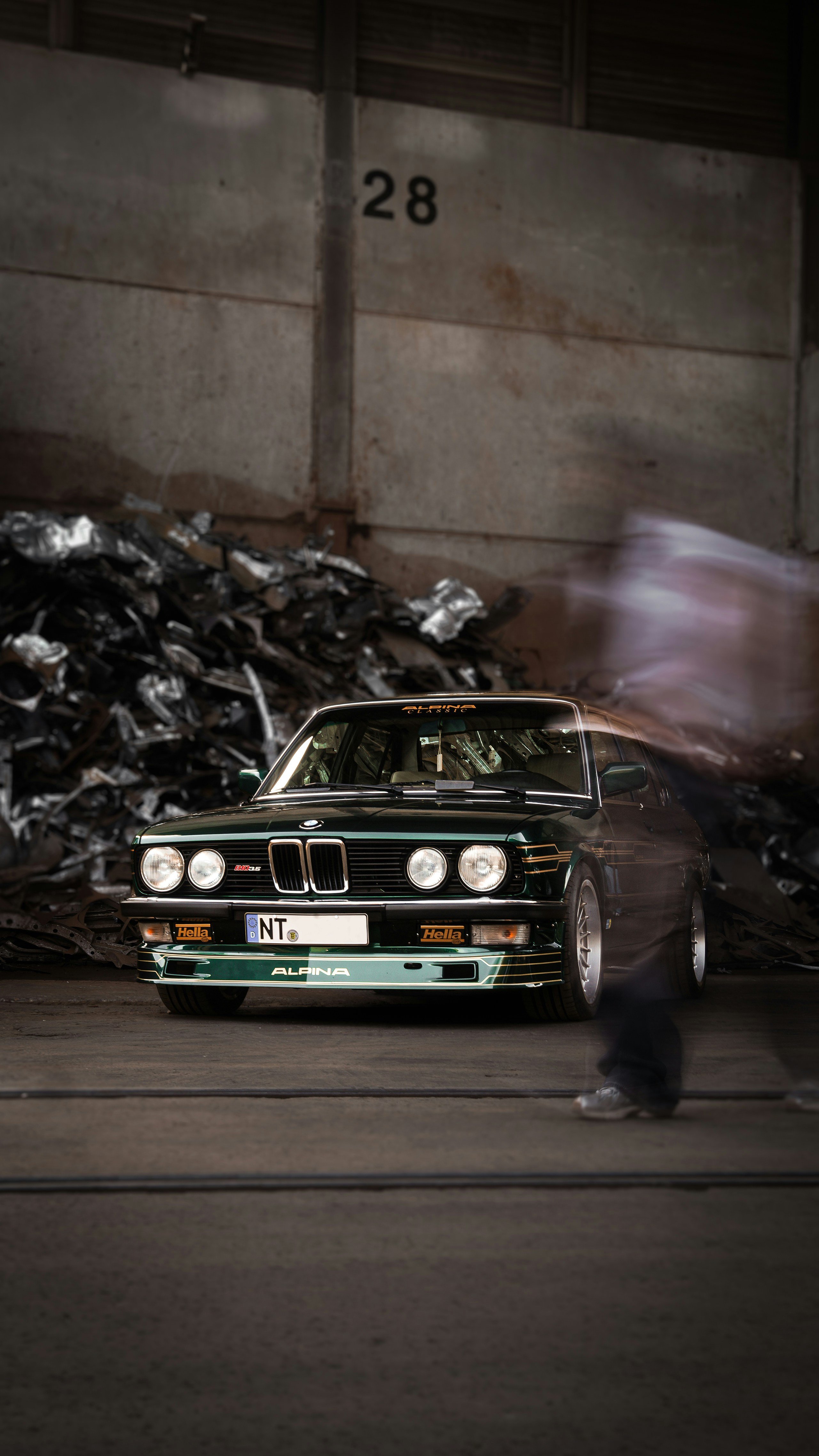 Green BMW Alpina in an industrial archive, captured with motion blur