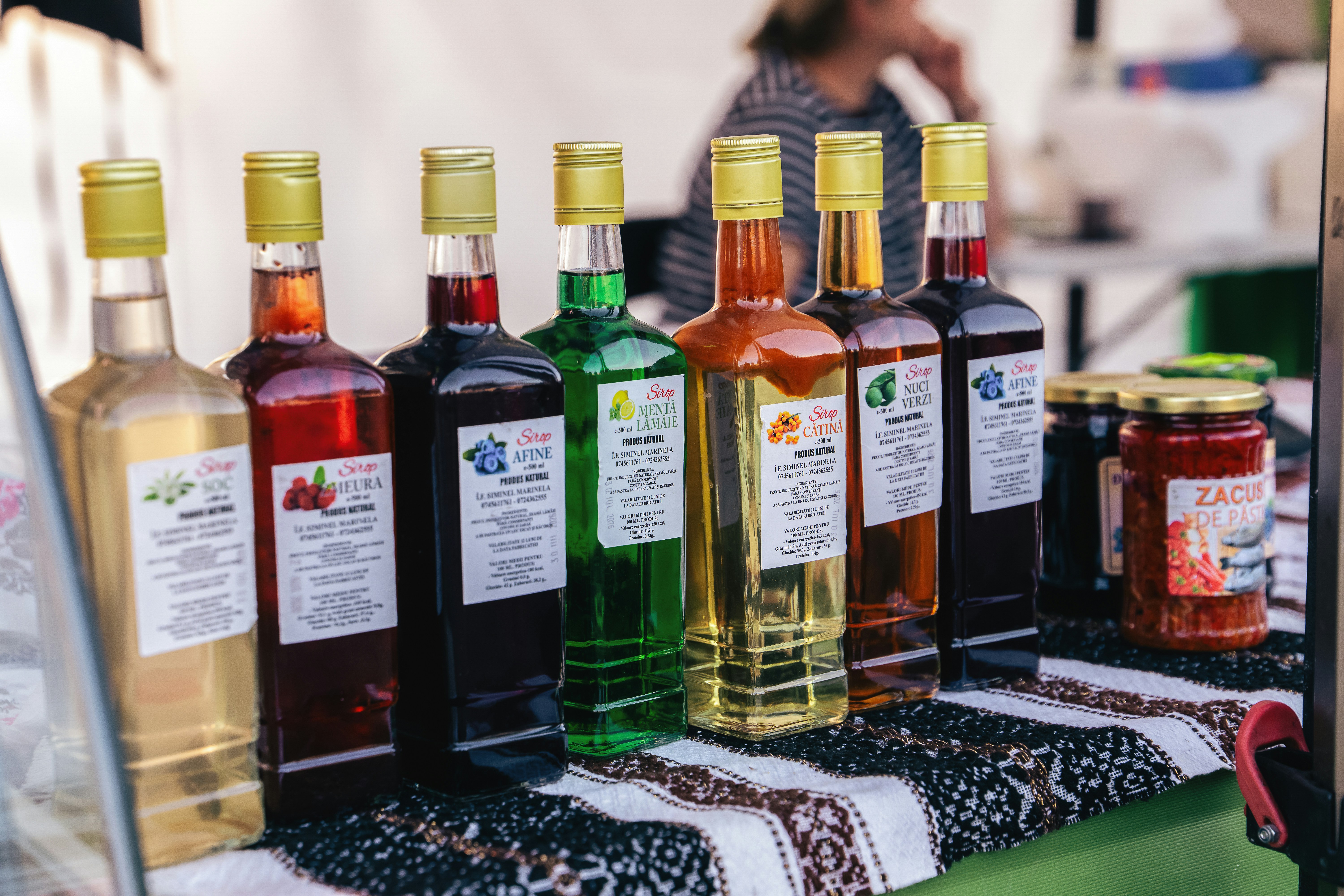 Row of colored liqueur bottles at a market stall