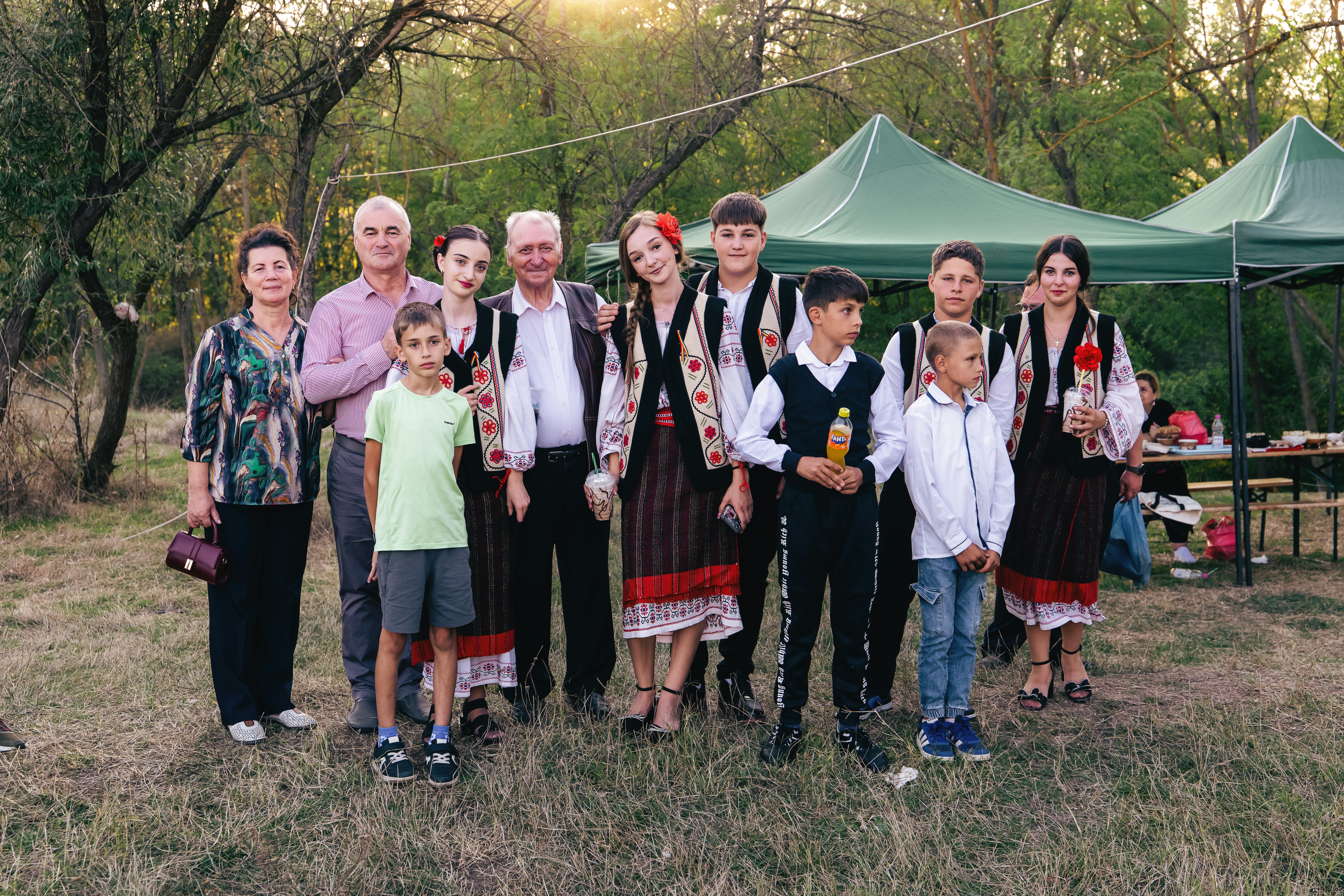 Family Portrait in Traditional Attire Under Green Canopies