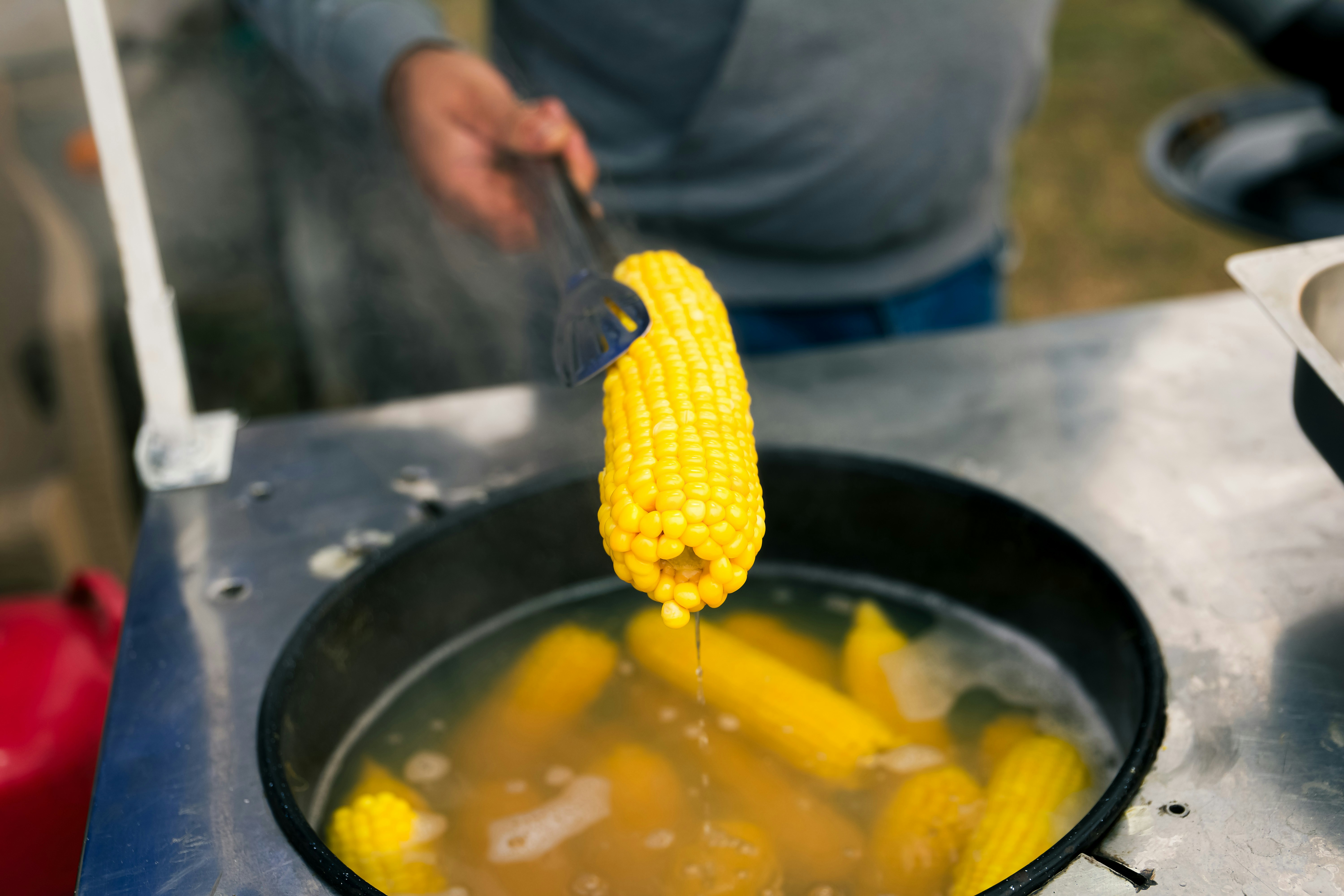 Golden corn on the boil: steam rising from a skillet pot