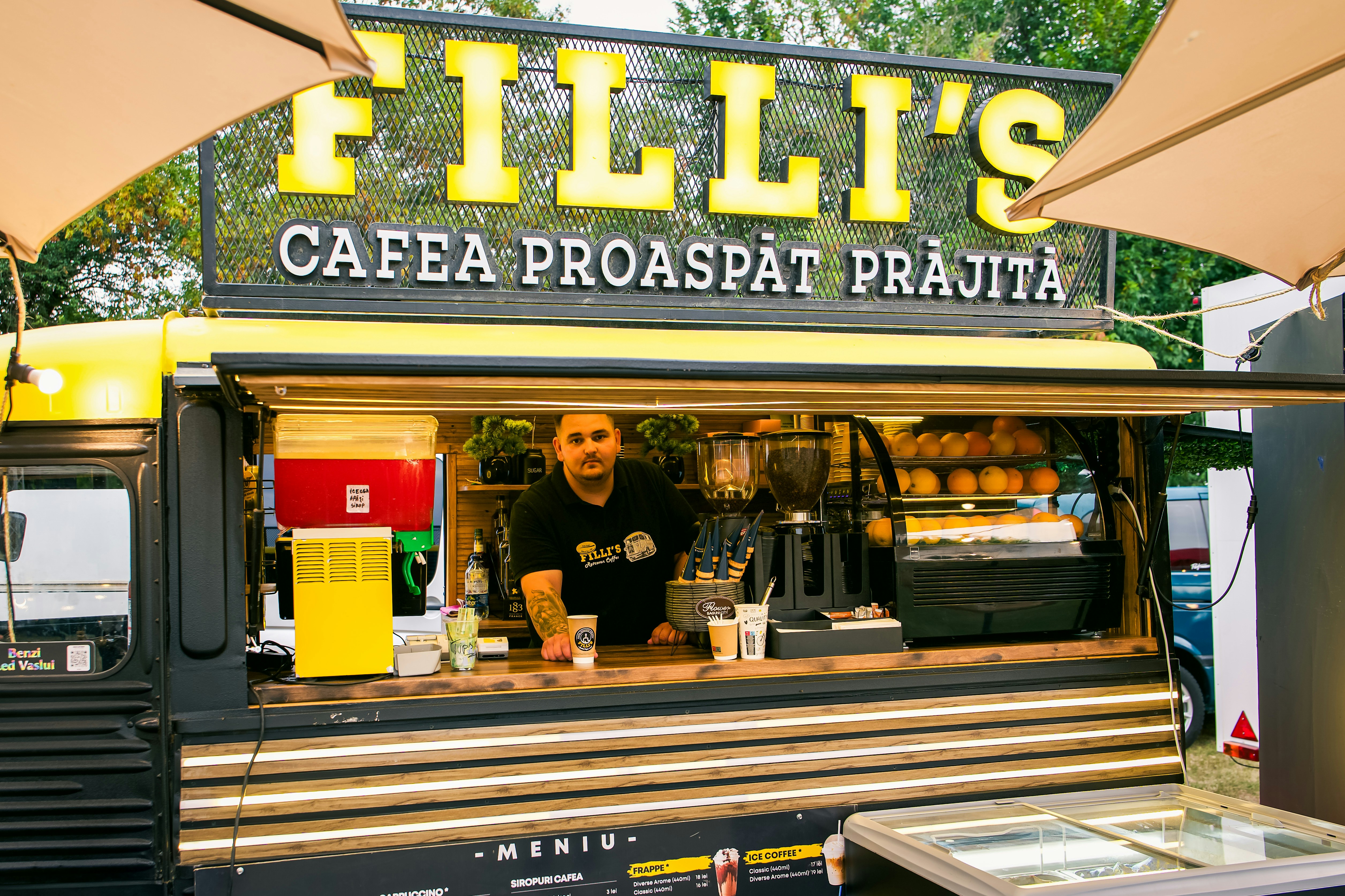 Bright Yellow Food Truck Stand with Barista at Work