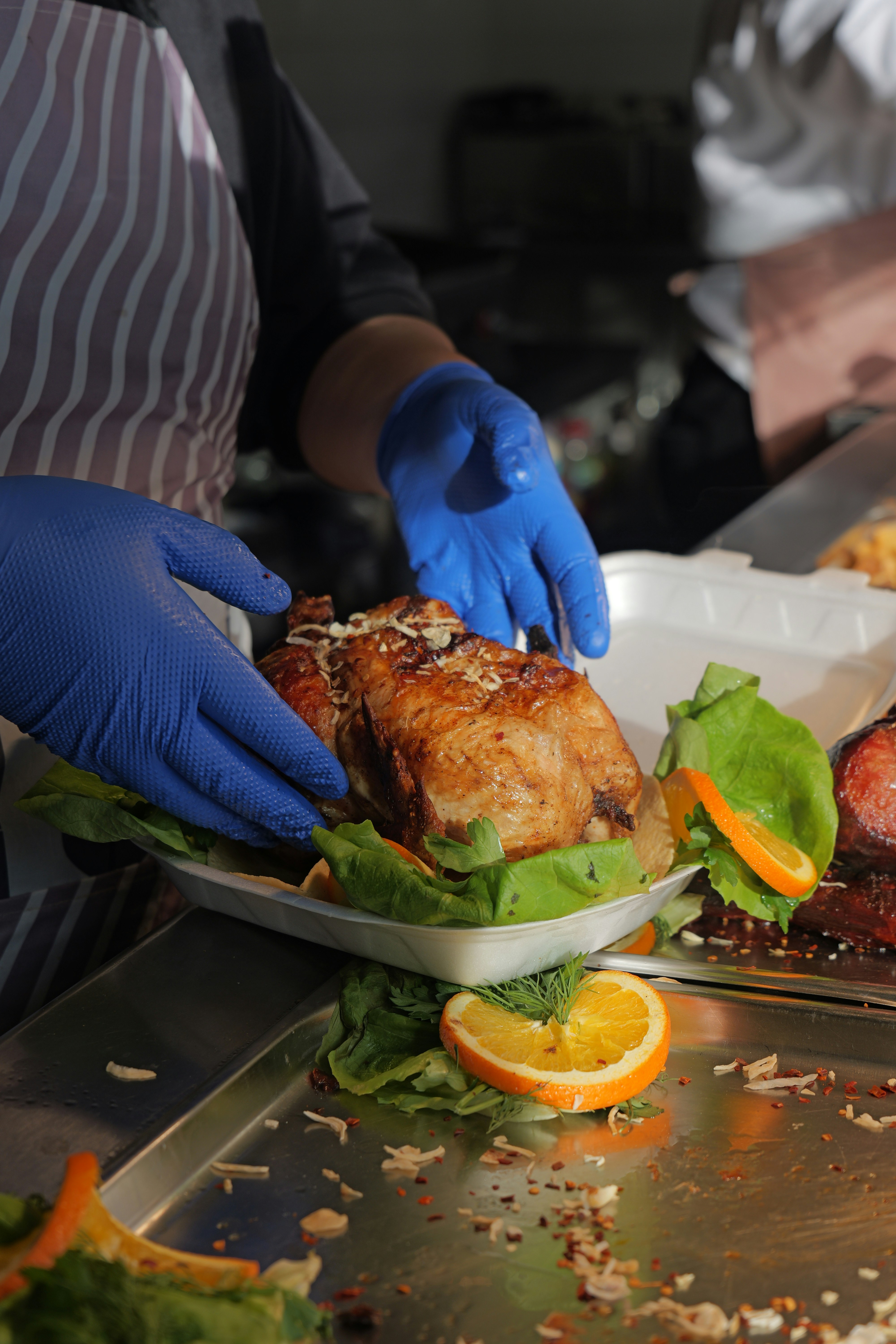 Gloved Hands Carve Roasted Chicken at a Catering Station