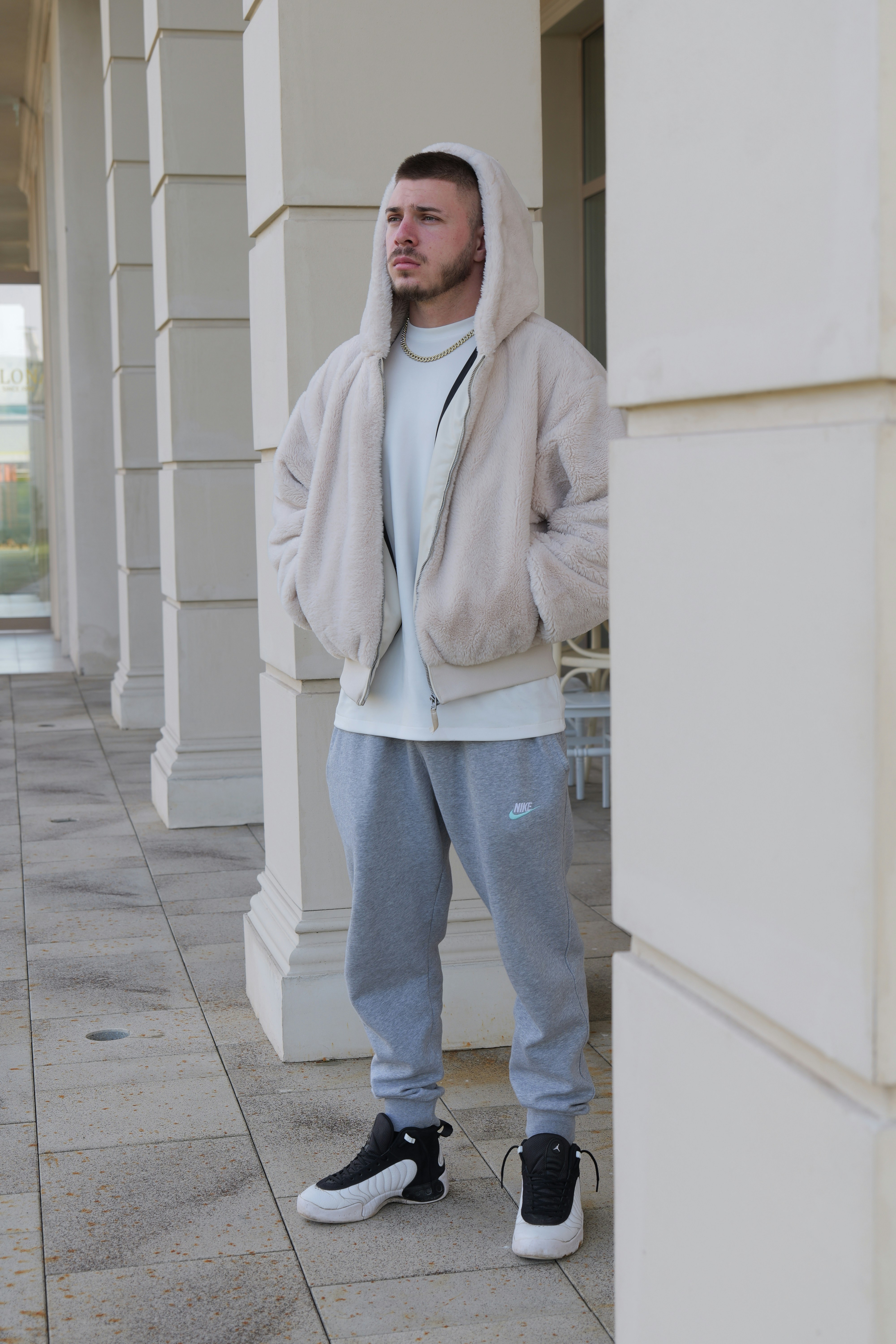 Urban hoodie: a confident stance against a column-lined facade