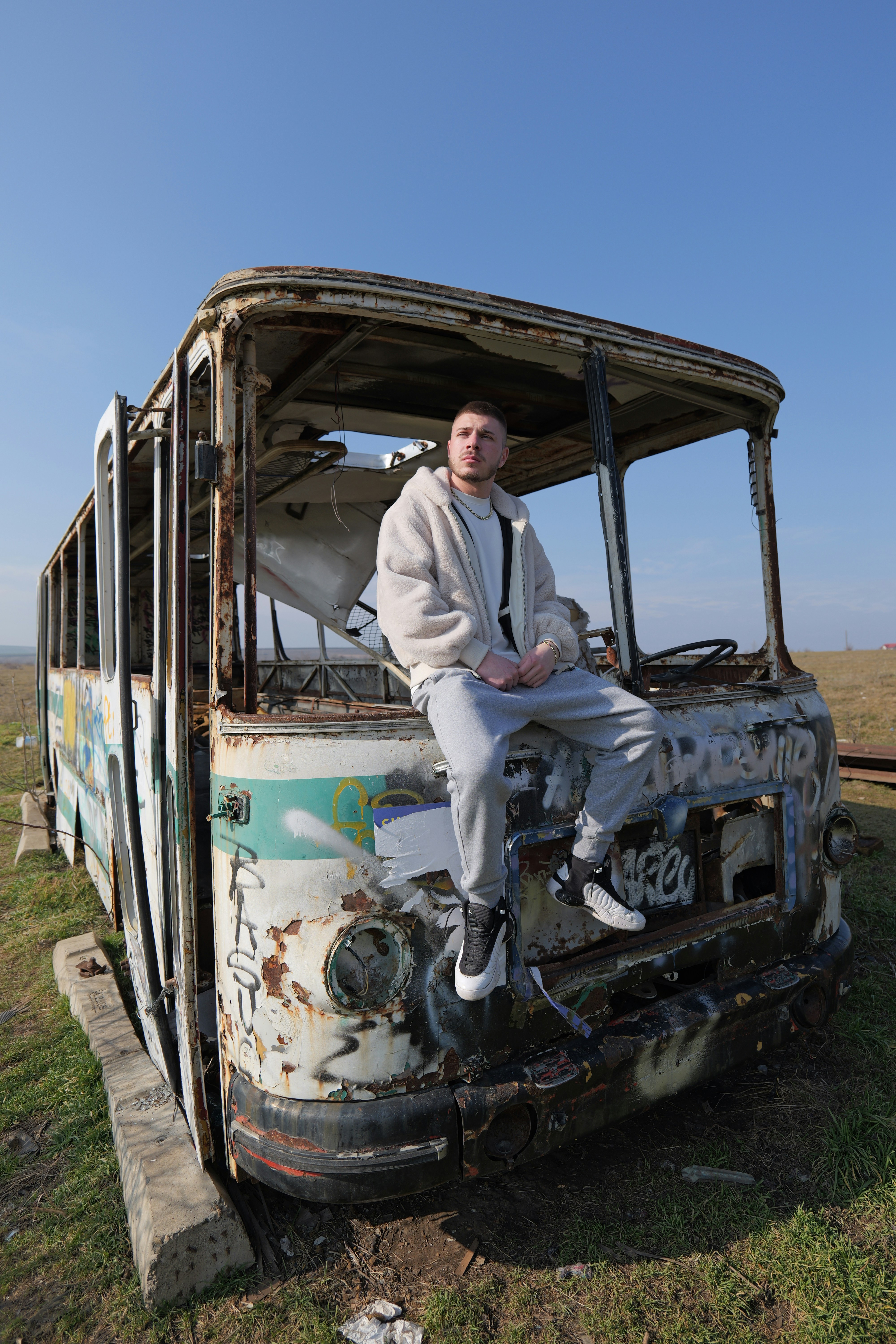 Rusted bus, calm gaze: lone youth on the chewed frontier