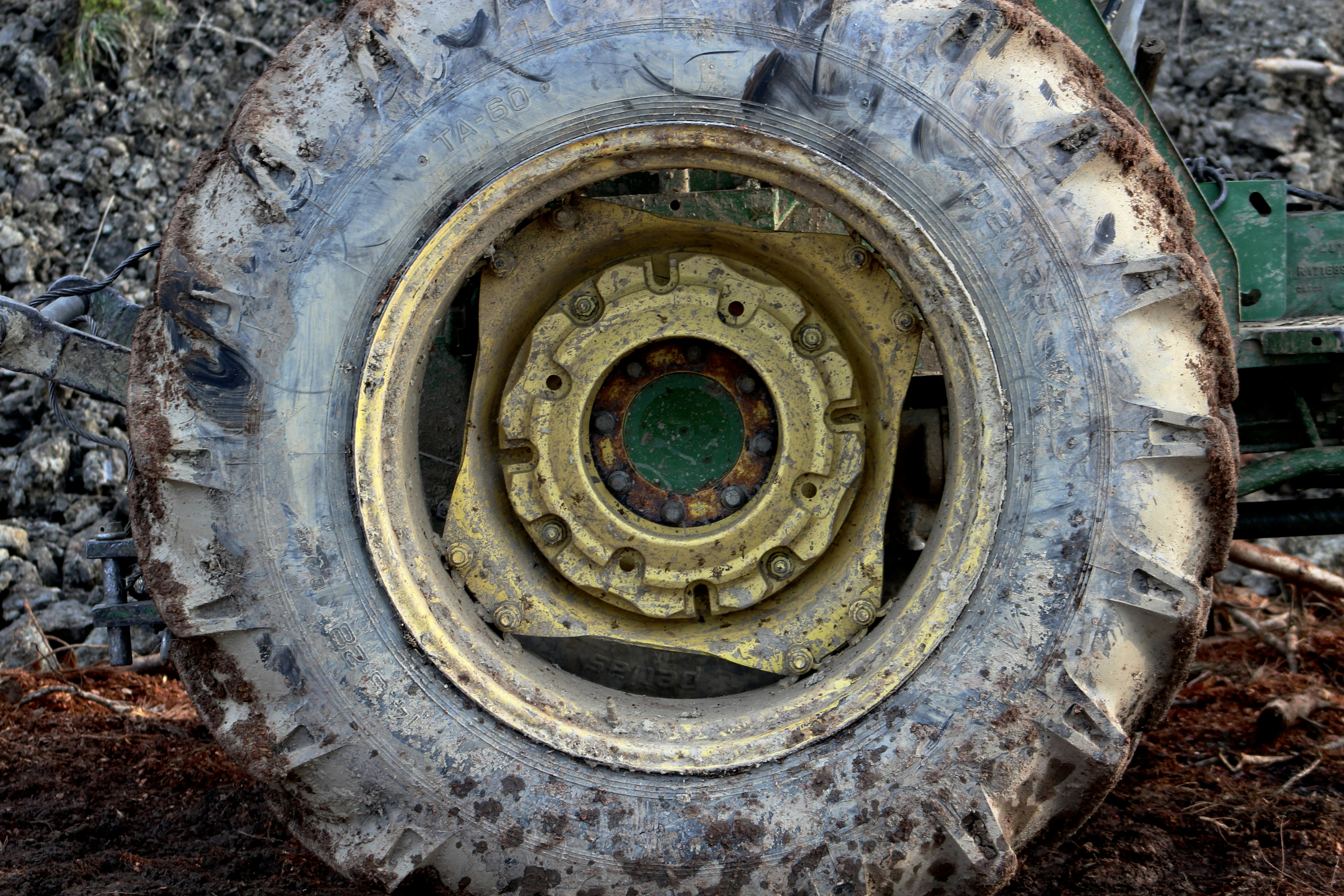 Worn Green Tractor Wheel: A Closer Look at Grounded Machinery