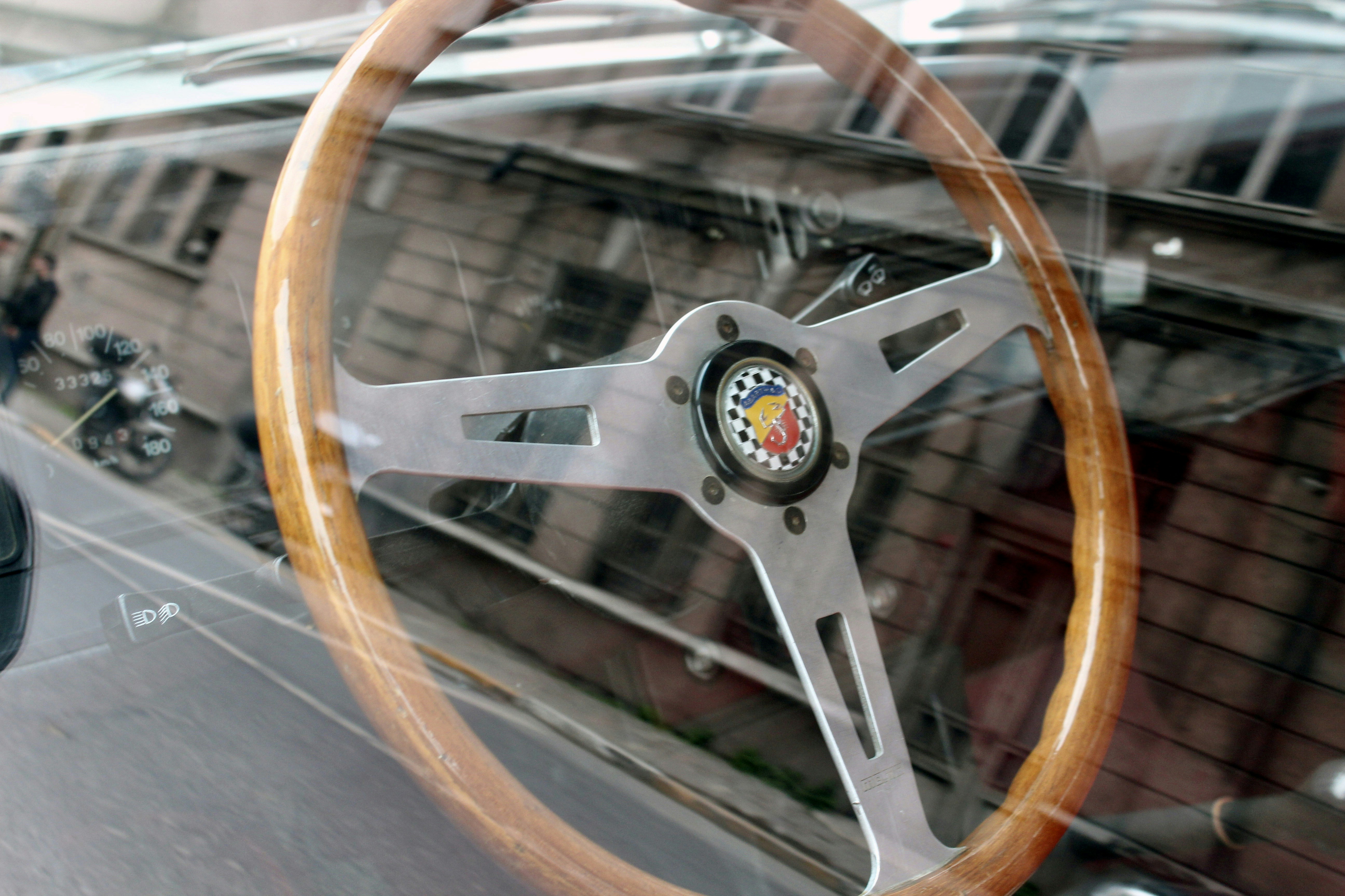 Vintage Wooden Steering Wheel Reflected in Glass