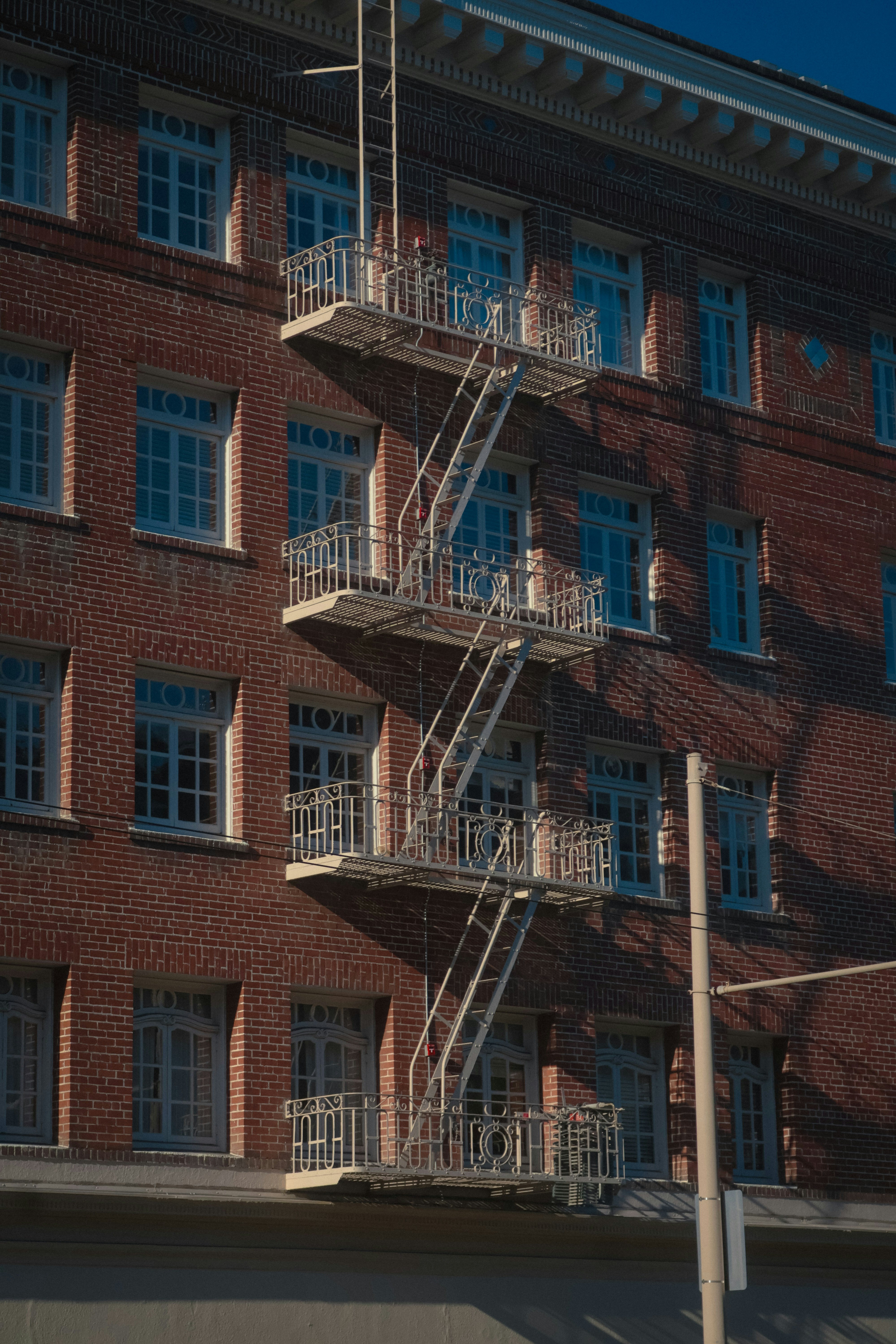 Sunlit Fire Escape Carved into a Red Brick Loft