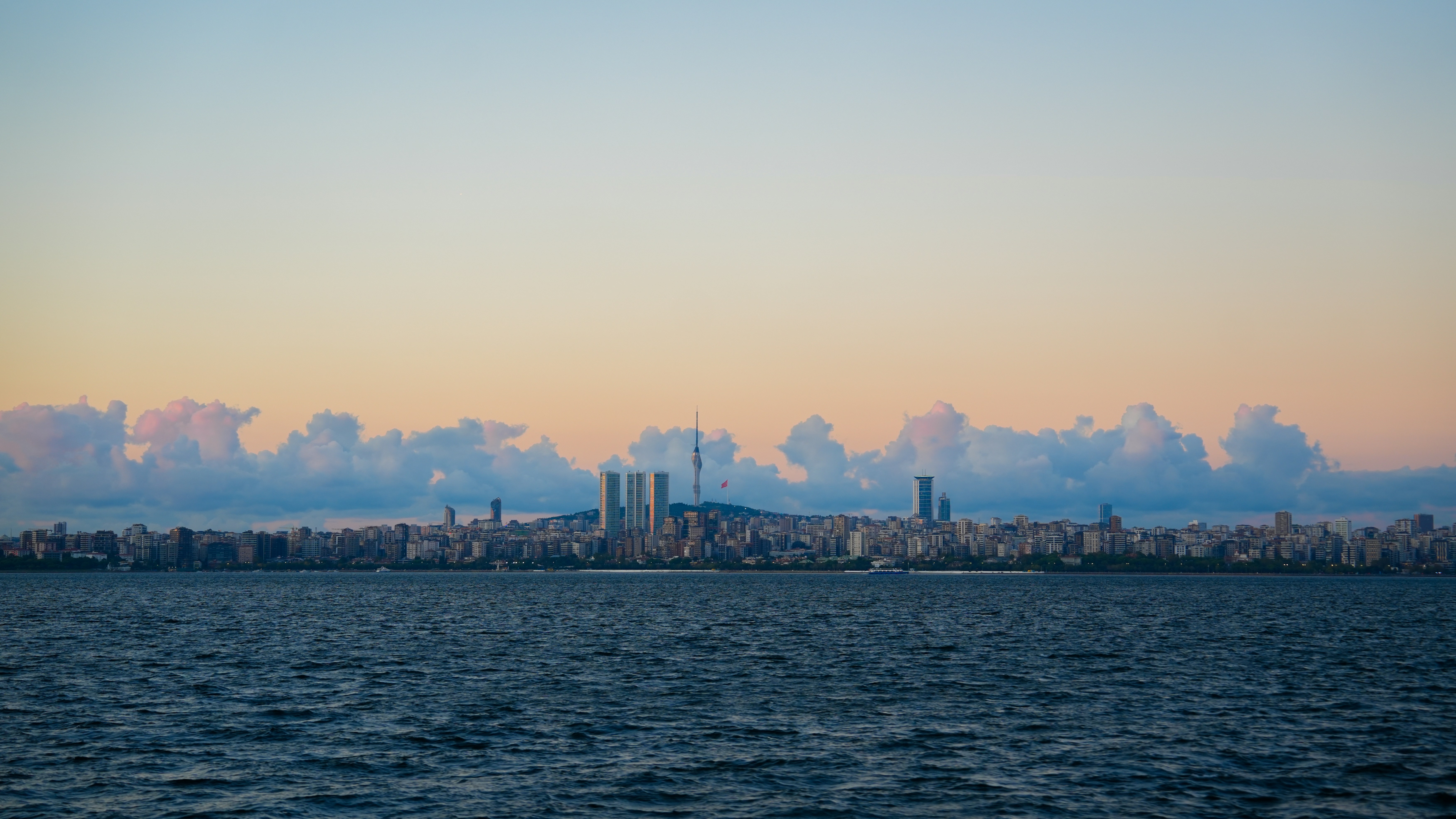 Distant Skyline Sails Above the Quiet Sea at Dusk