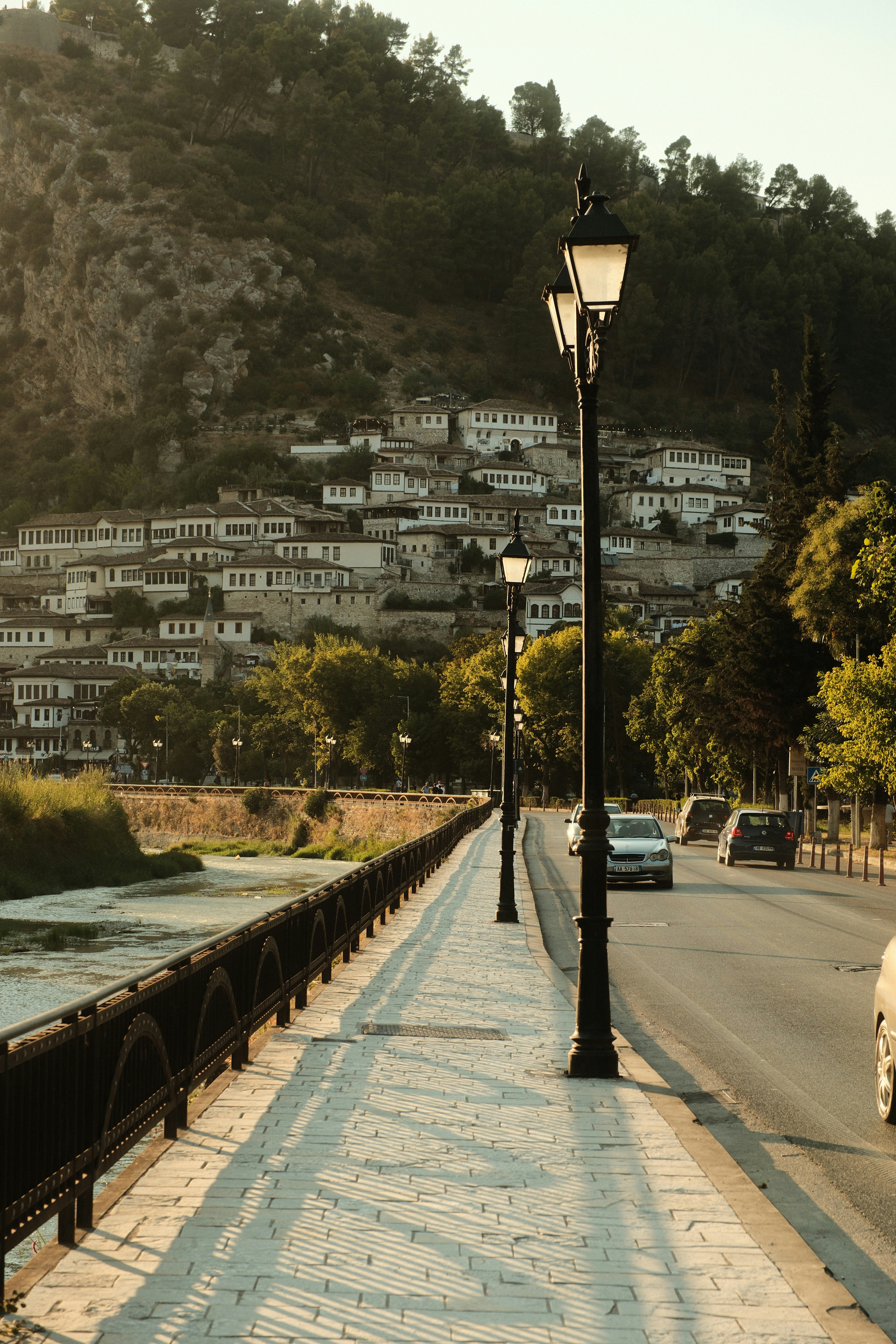 Sunlit Riverside Lane with Lanterned Promenade