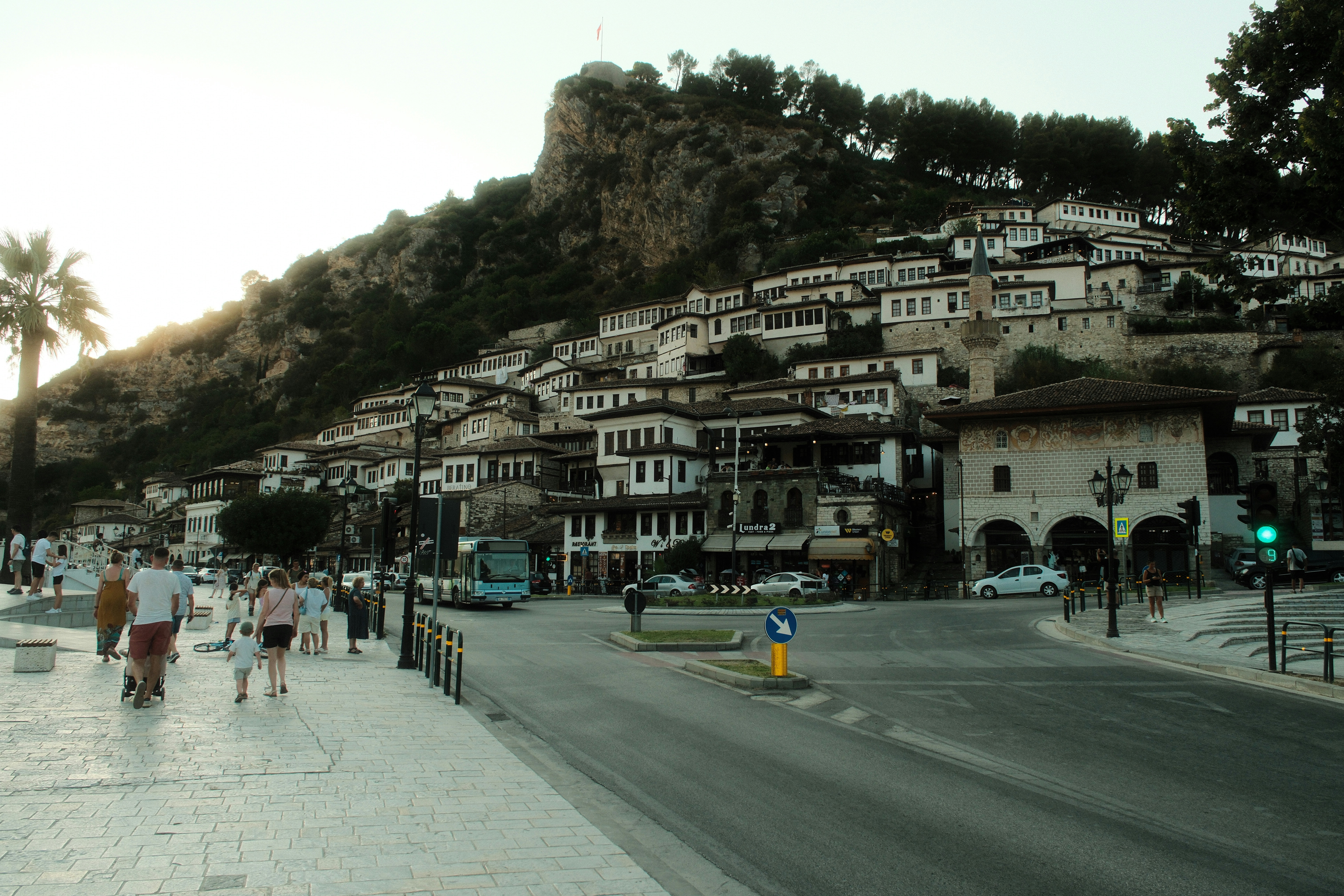Harbor town hillside: stone archways and pastel facades under a fading sun