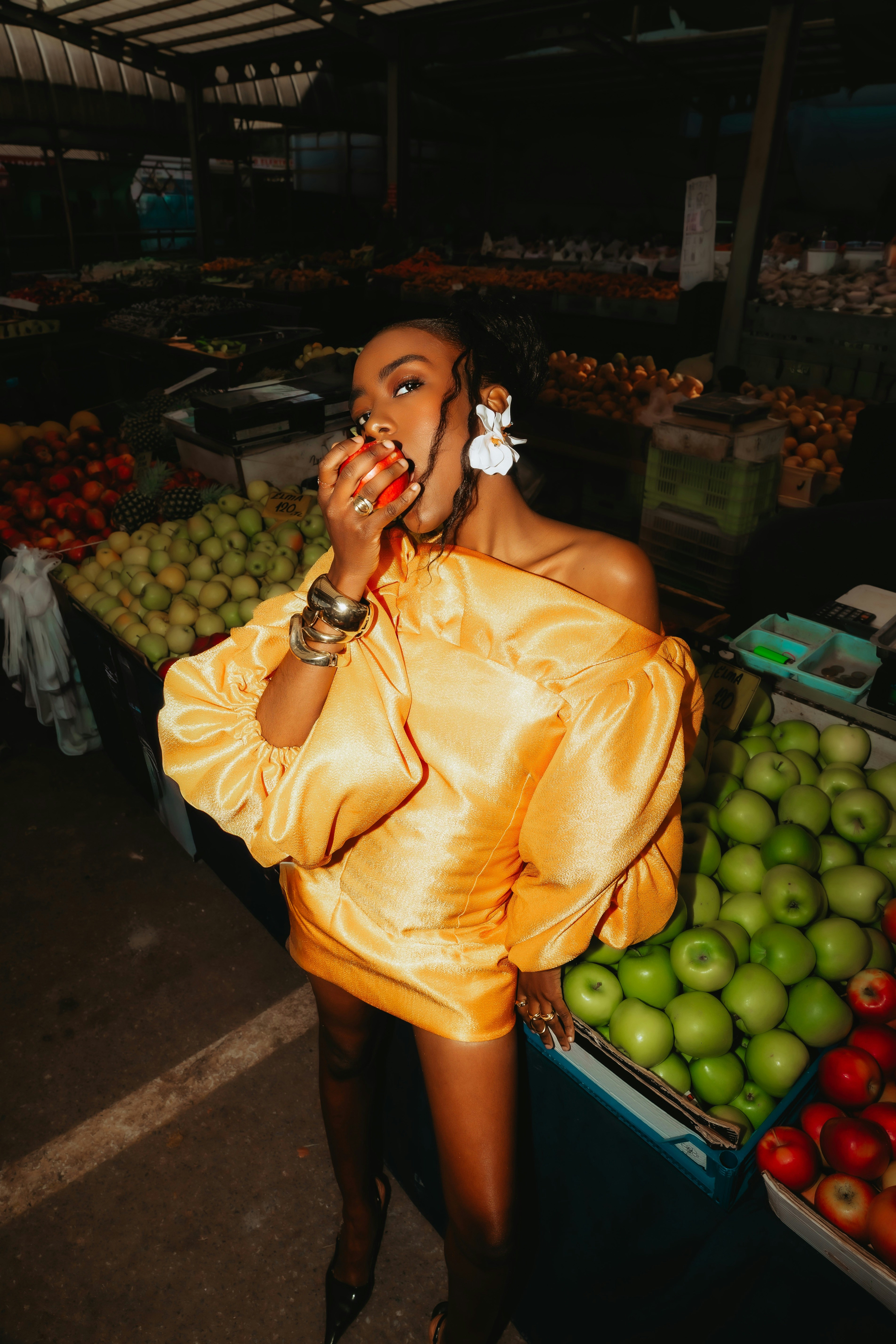 Orange Glow in the Market: A Bold Portrait Amid Fruit Stacks