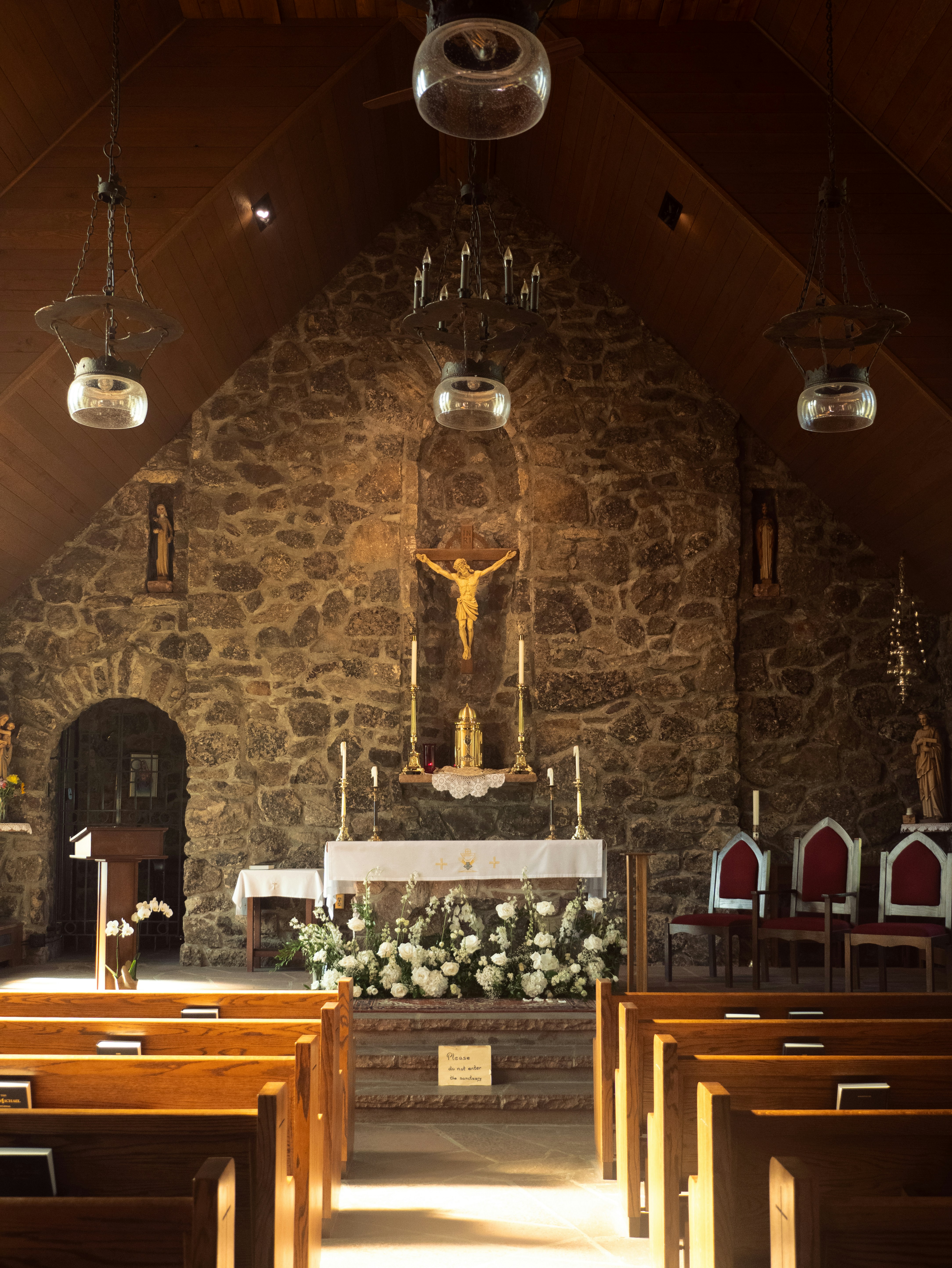 Silent Sanctuary: Altar framed by stone walls and wooden pews