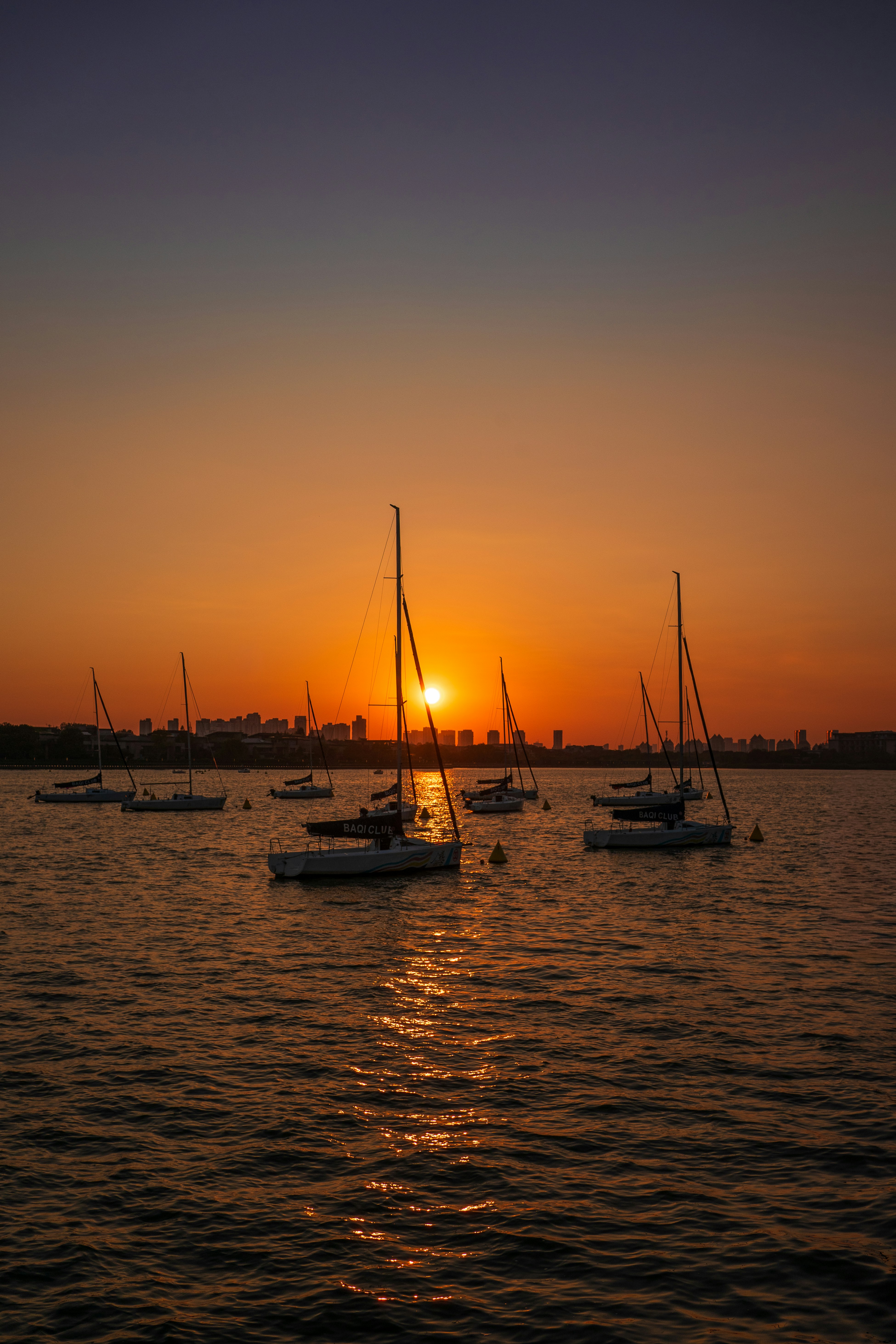 Sunlit Marina at Dusk: Boats Silhouetted Against a Golden Horizon