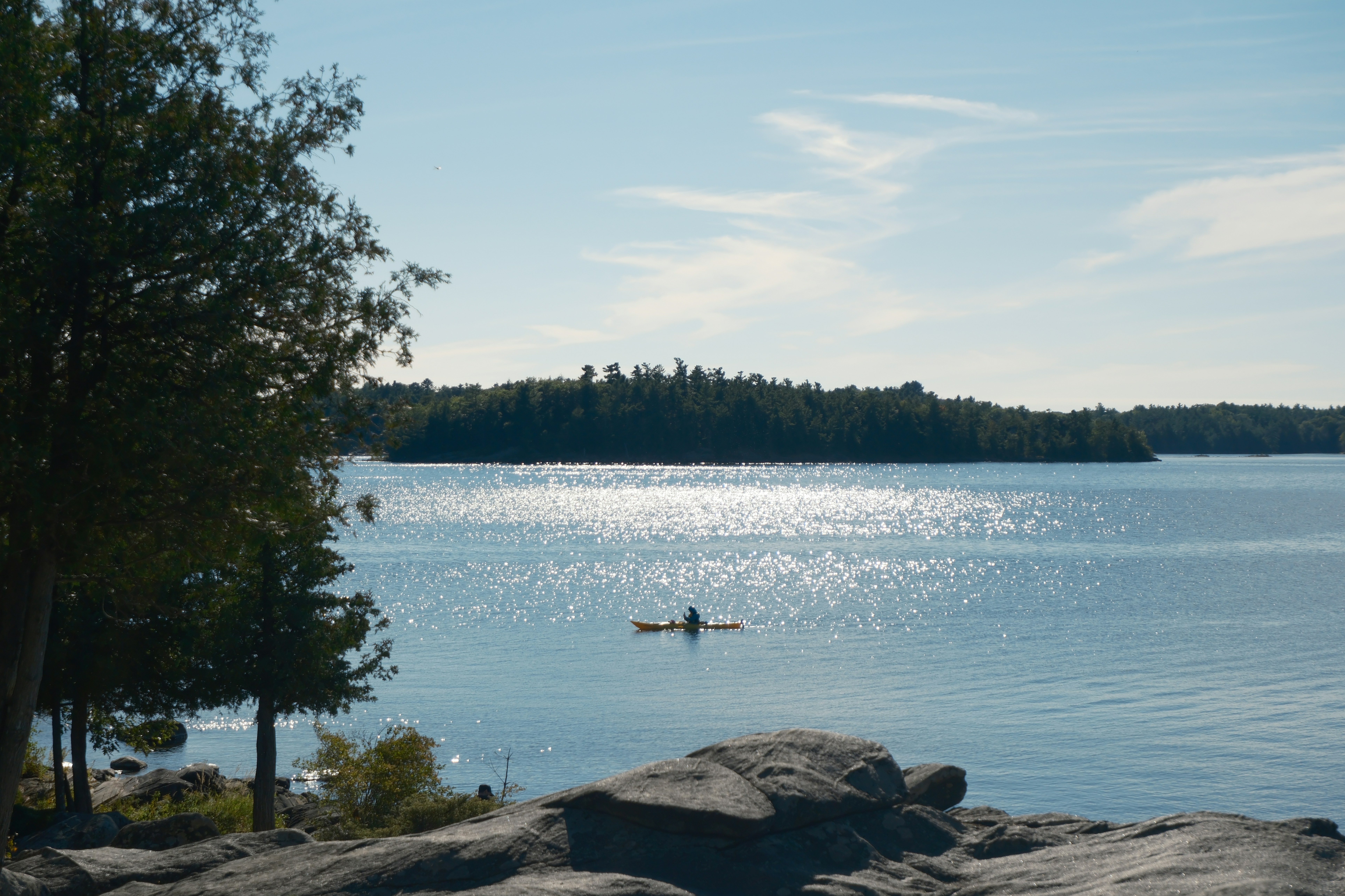 Sunlit Crest: A Quiet Canoe on a Sparkling Lake