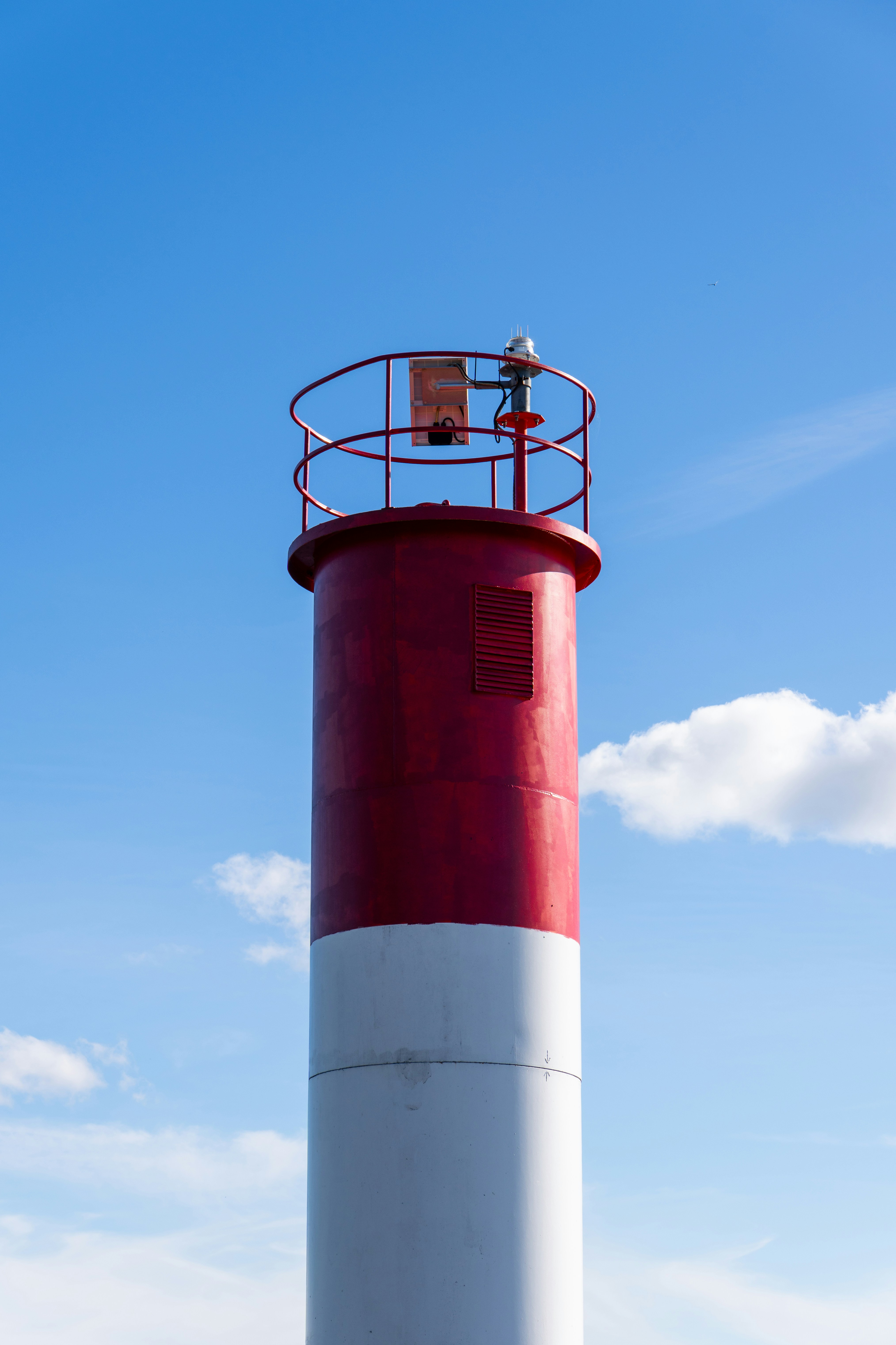 Red Lighthouse Tower Reaching Toward a Wide Blue Sky