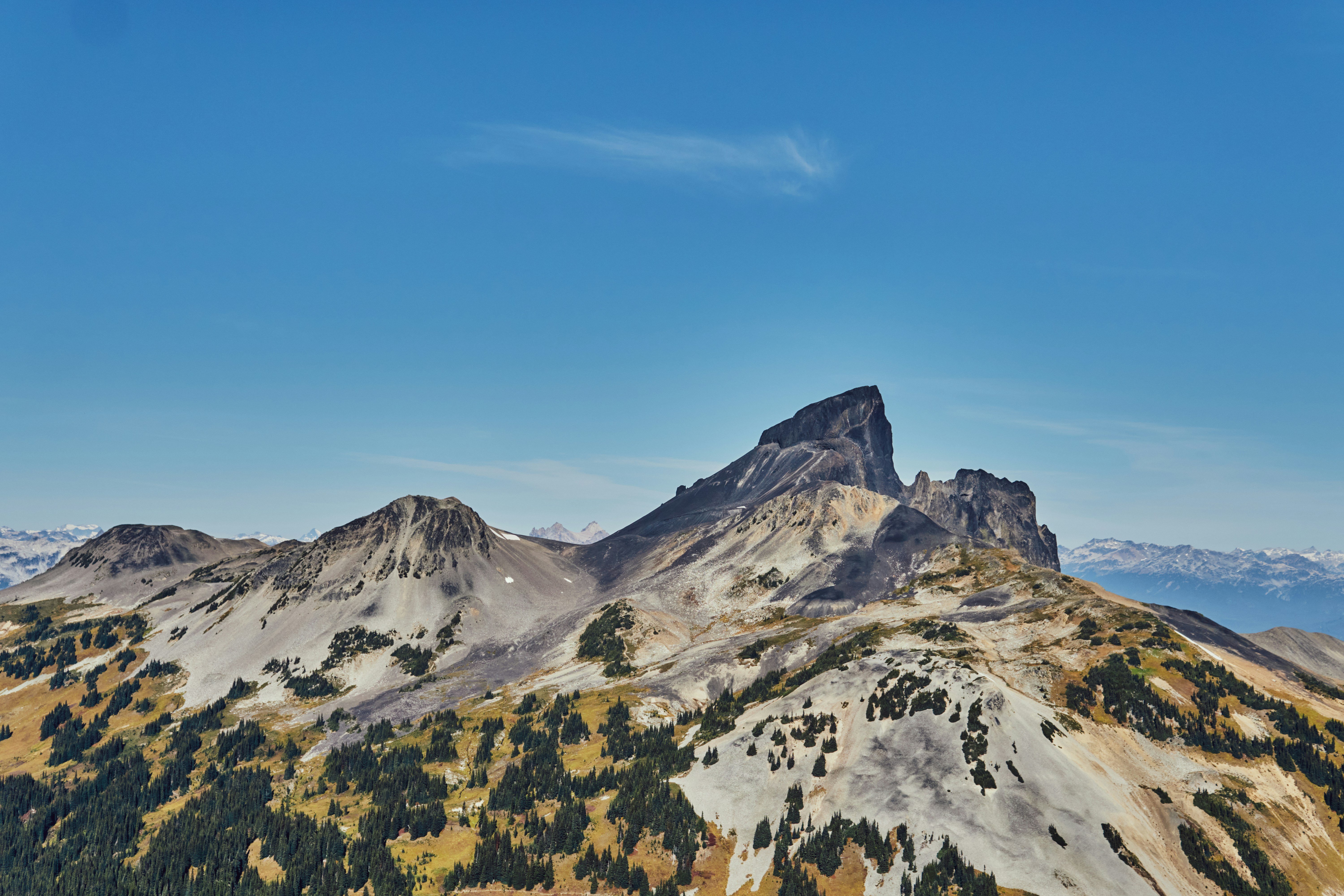 Peak Silhouette: A Majestic Mountain Canvas under a Clear Blue Sky