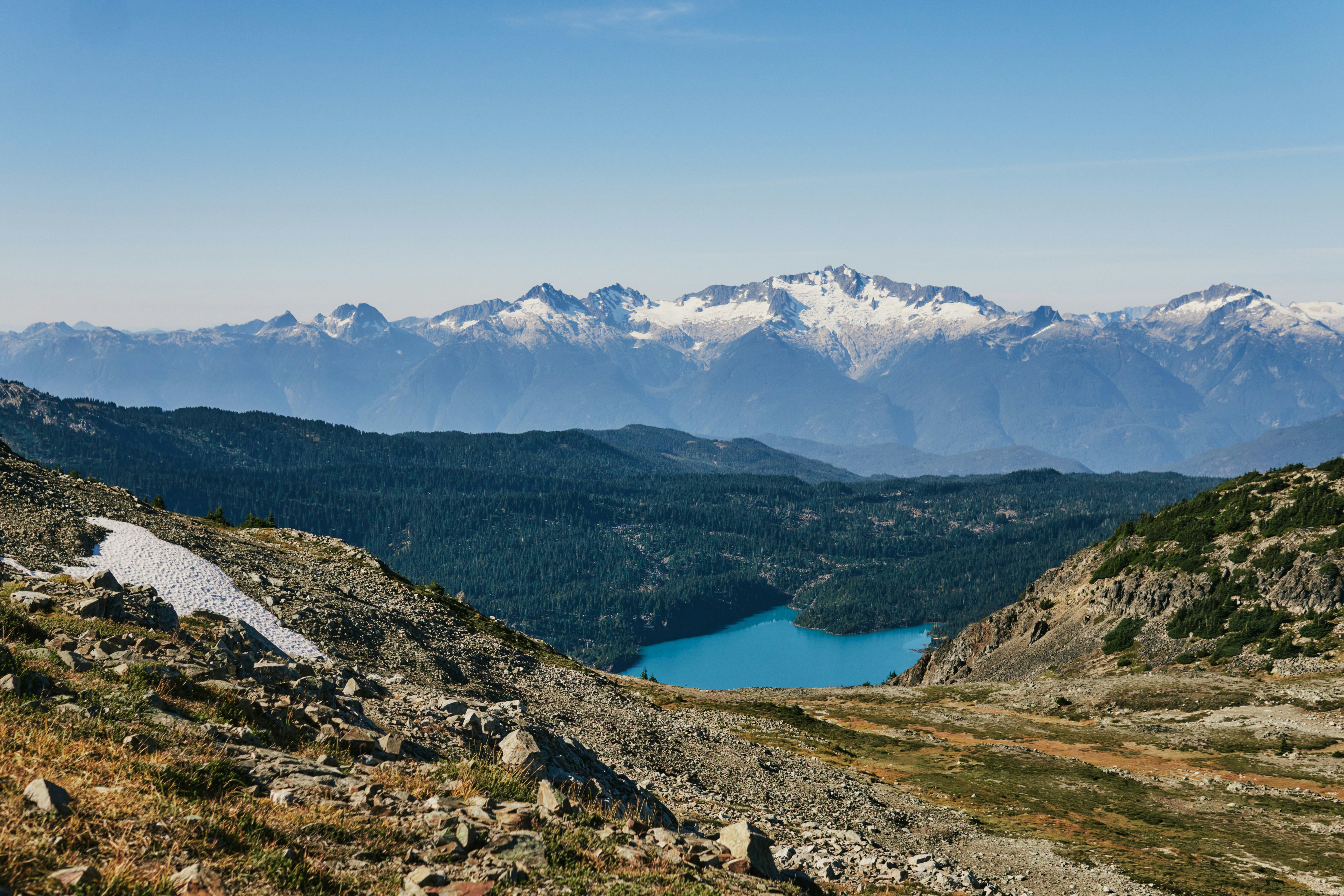 Azure Cradle: Snow-capped Peaks Guard a Dreamy Alpine Lake