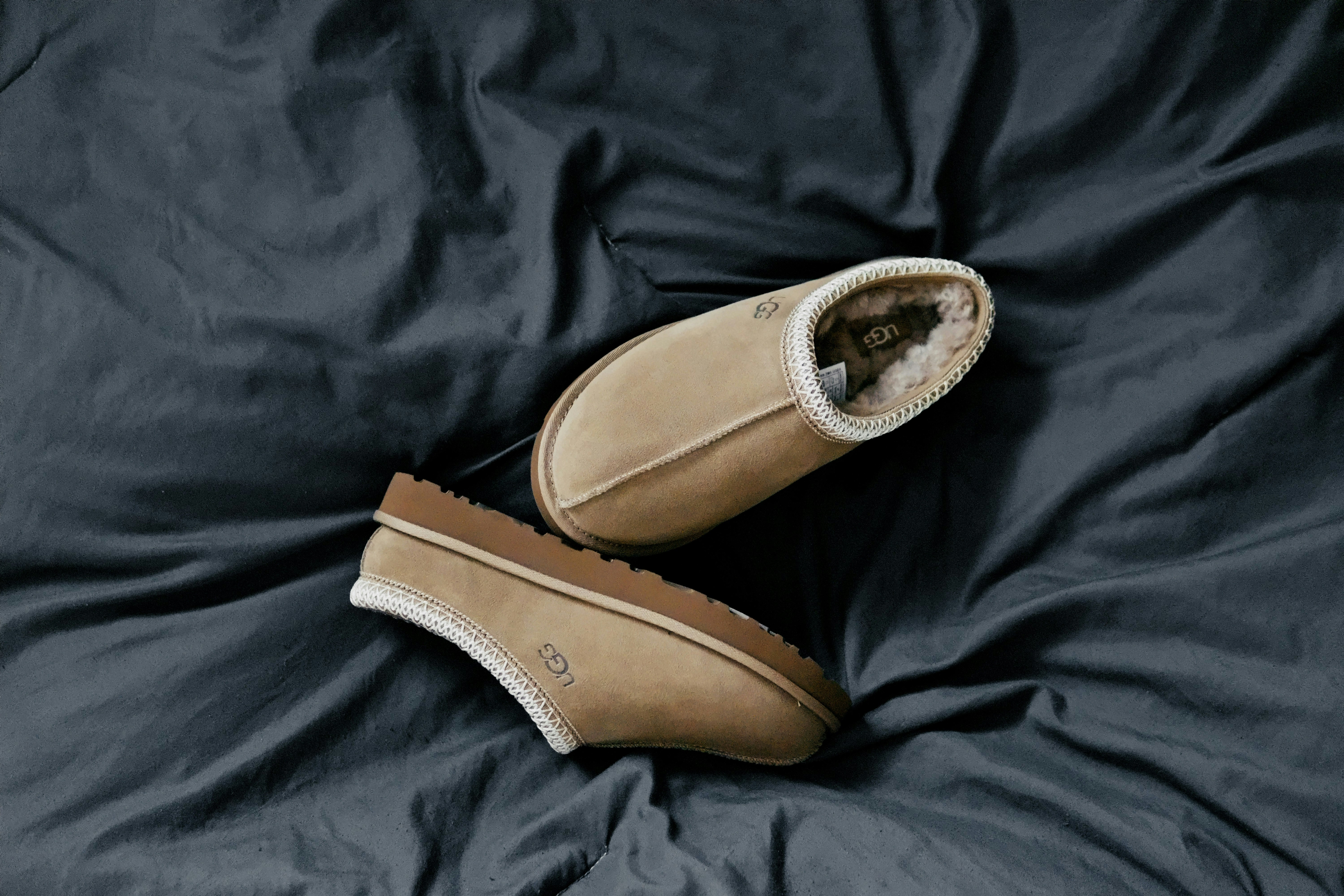 Brown moccasins resting on dark fabric bed