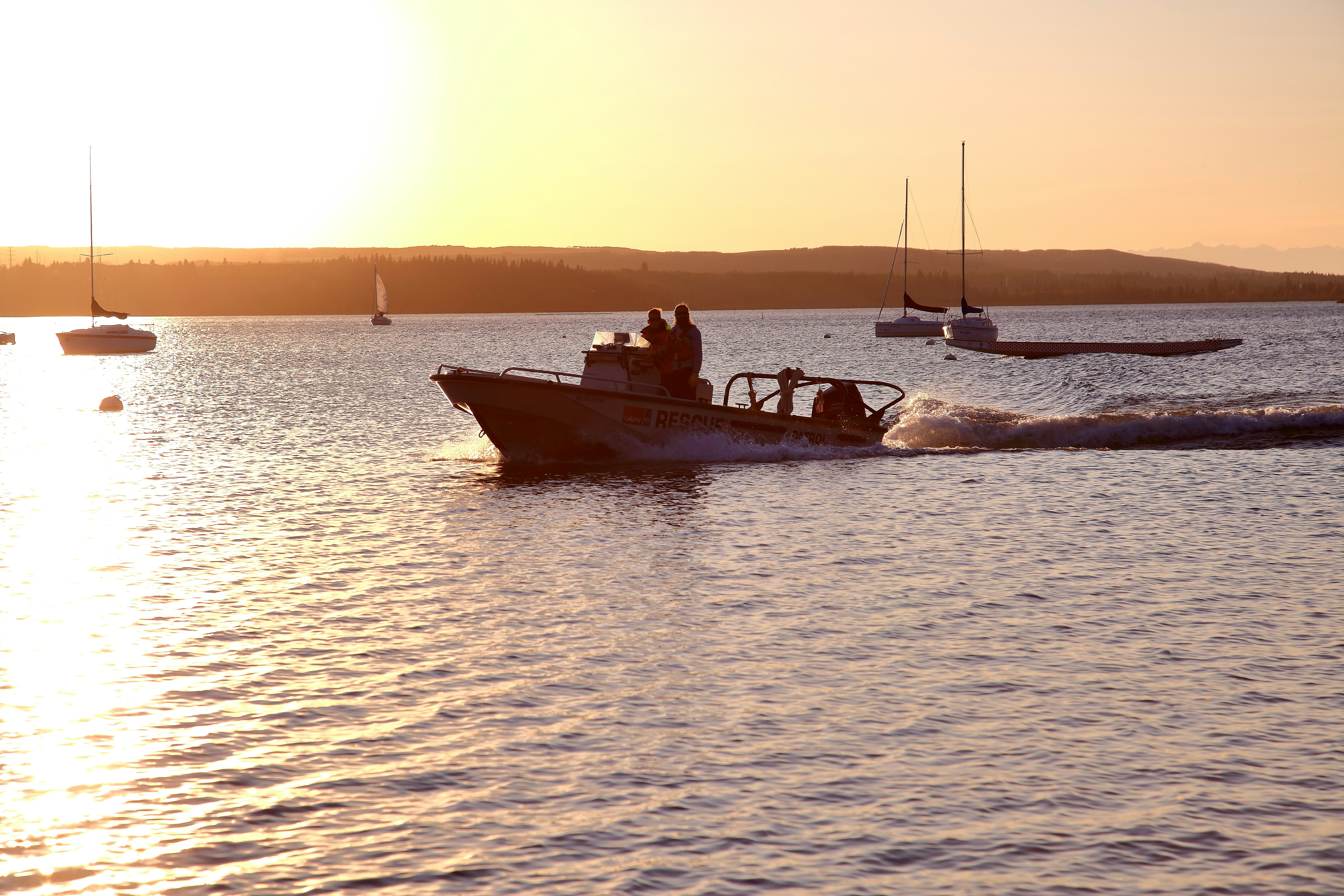 Sunlit Wake: A Motorboat Carves Toward the Horizon