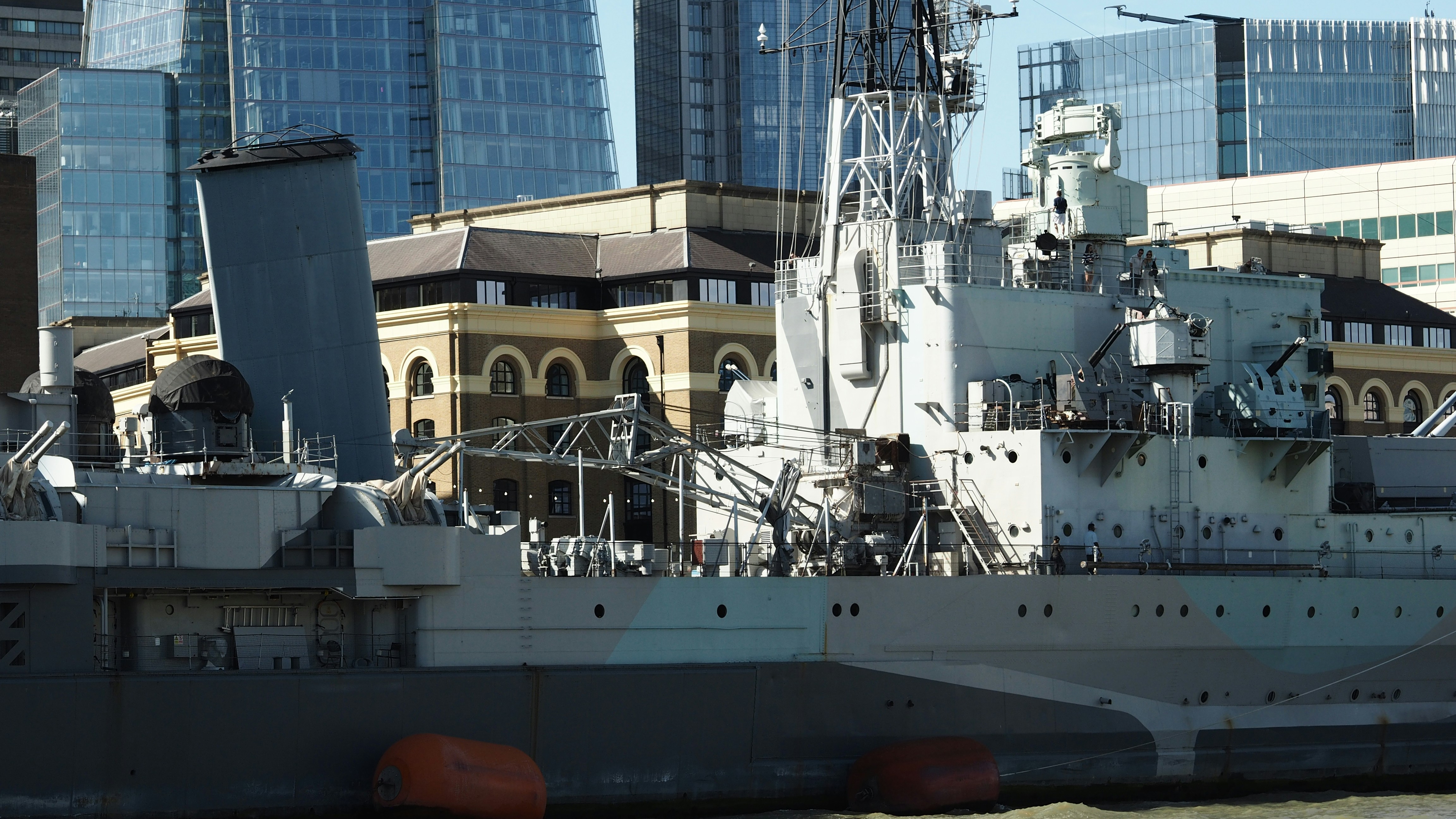 Harbor Hulk: A naval silhouette against a glass-and-steel skyline