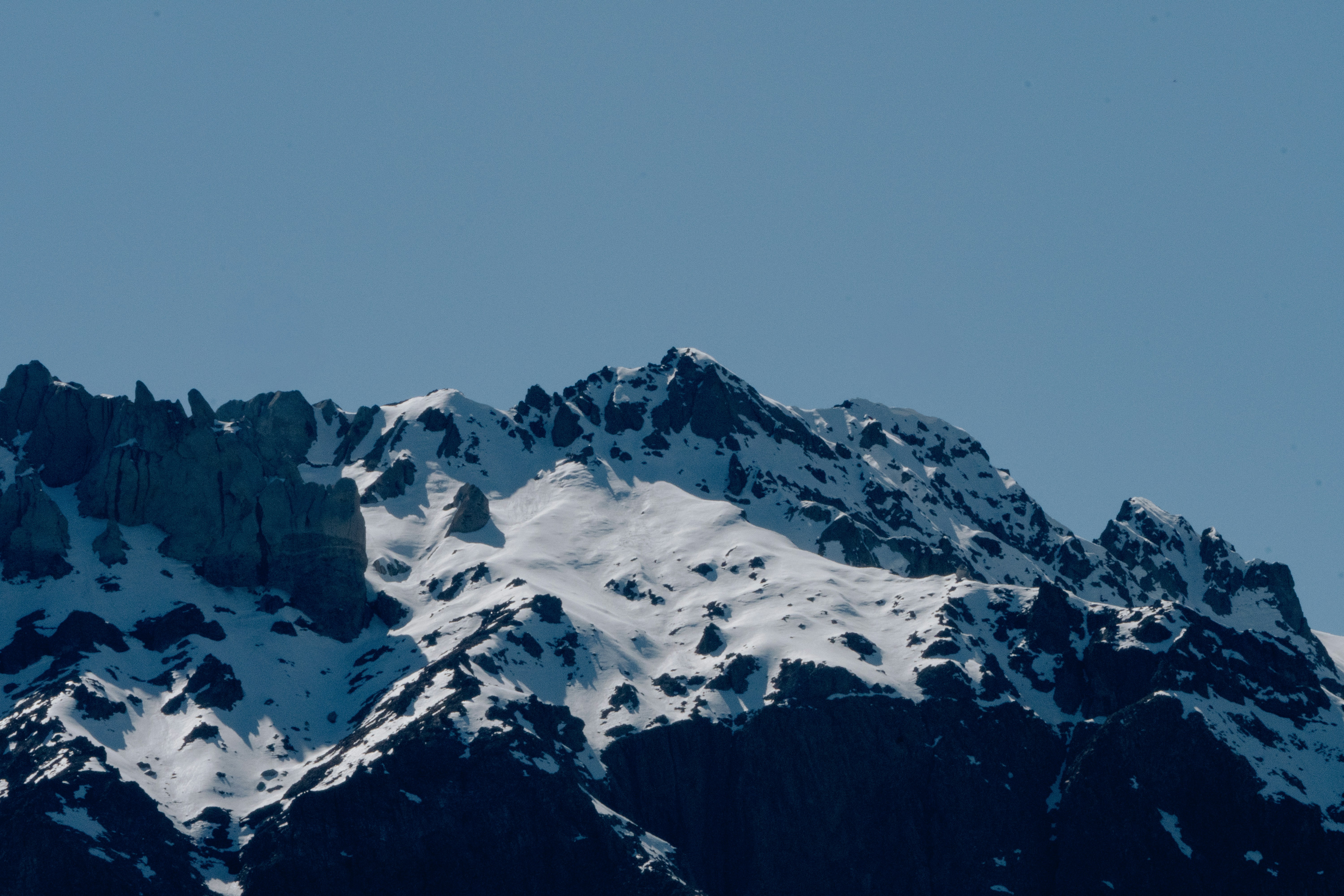 Snowbound Summit Silhouette Against a Clear Alpine Sky