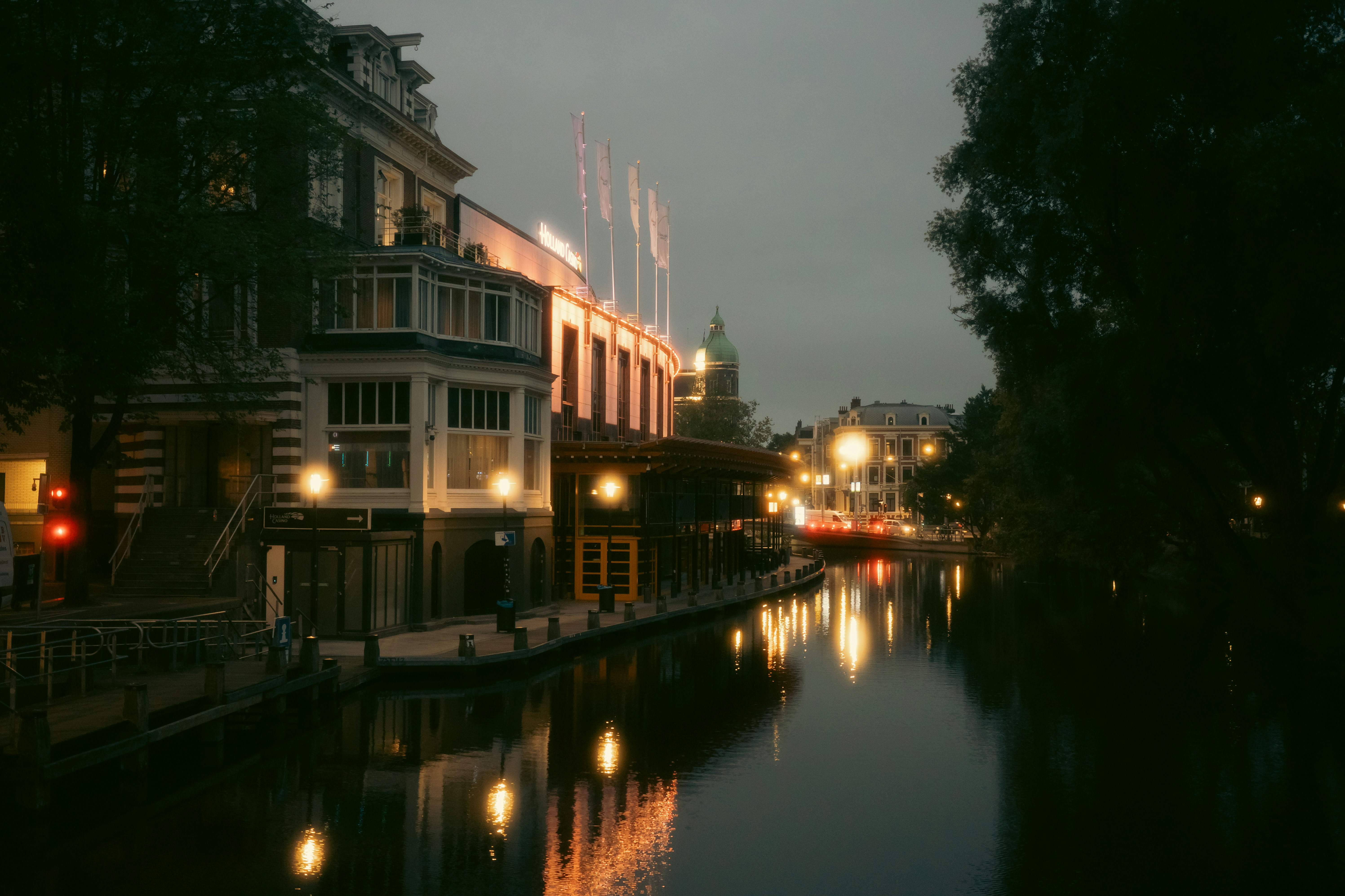  twilight canal lights lace the timbered facades along a quiet urban waterway