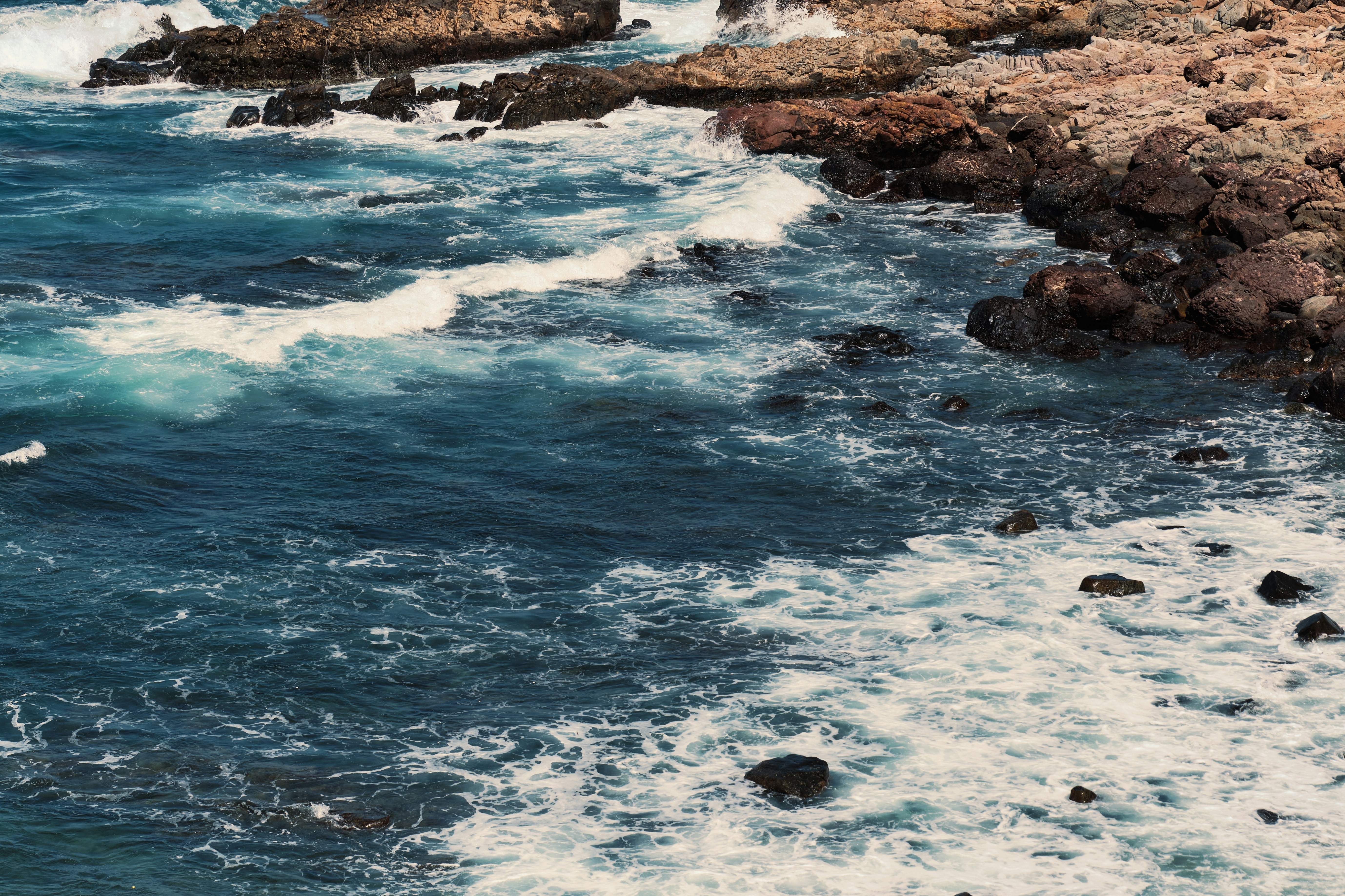 Rugged coastal blues: foam, rock and sea in motion