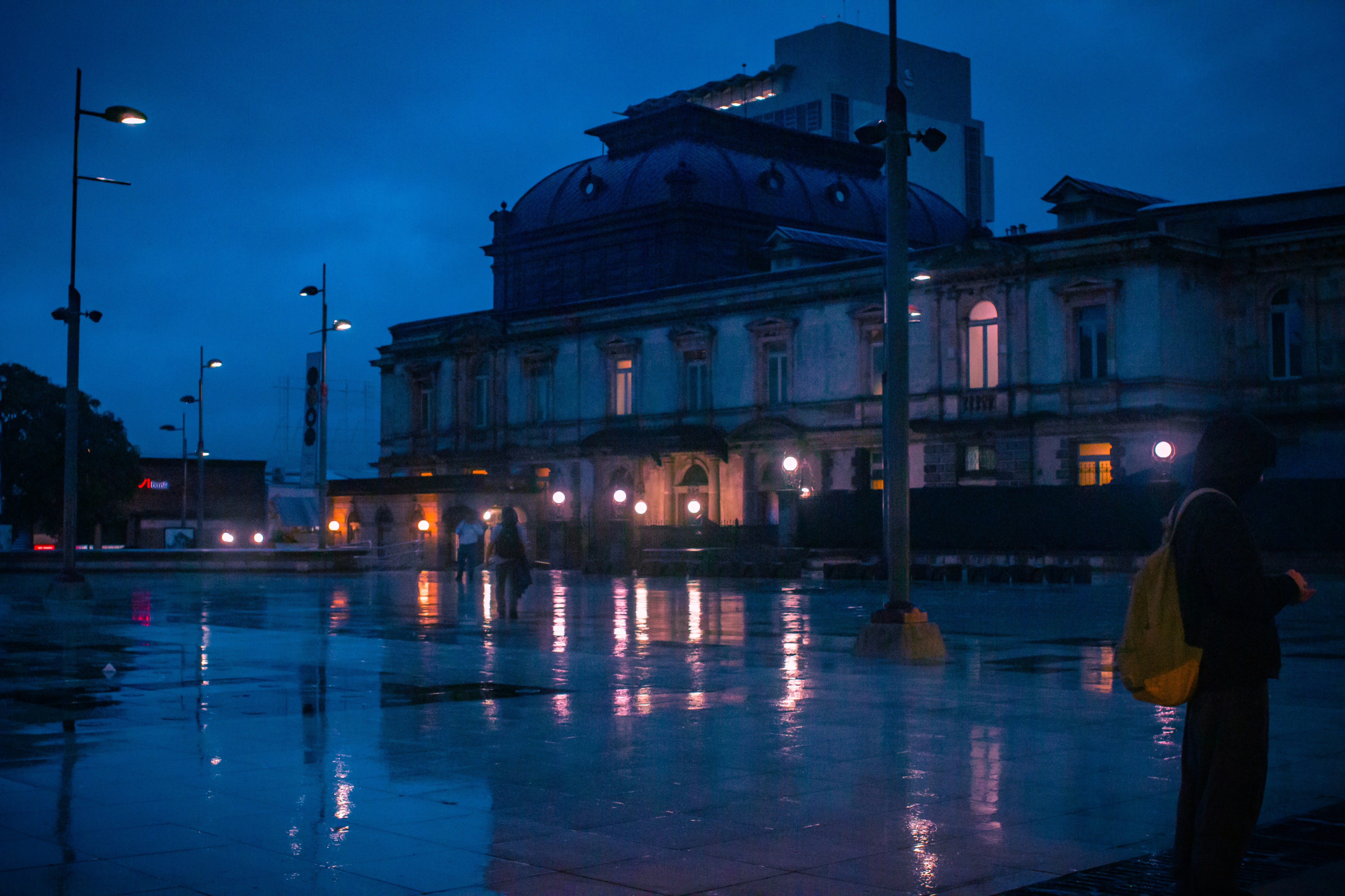 Moonlit Courtyard: Wet Pavement Reflects the City Lights