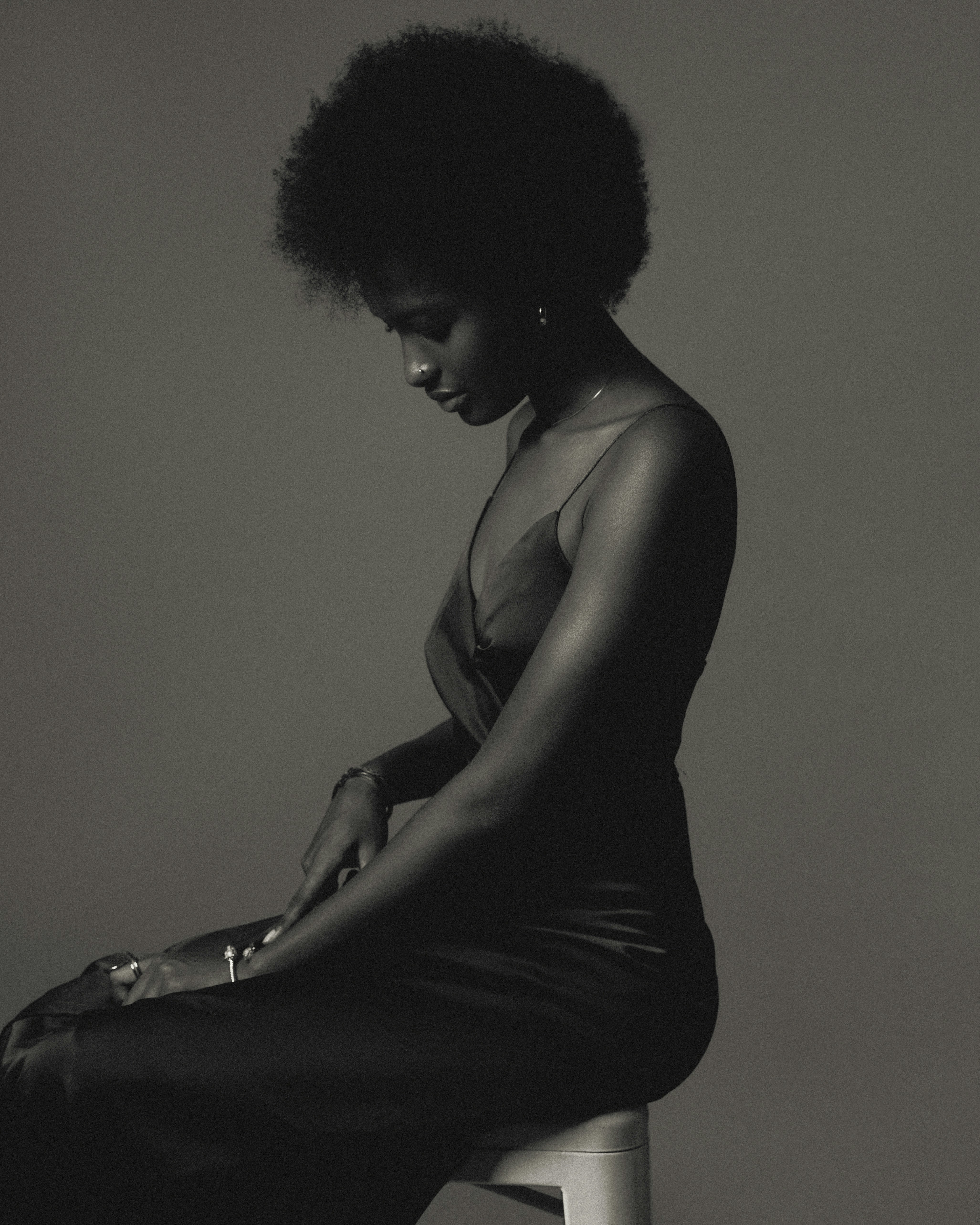 Silhouette in Shadow: A Quiet Poise on a Velvet Seat