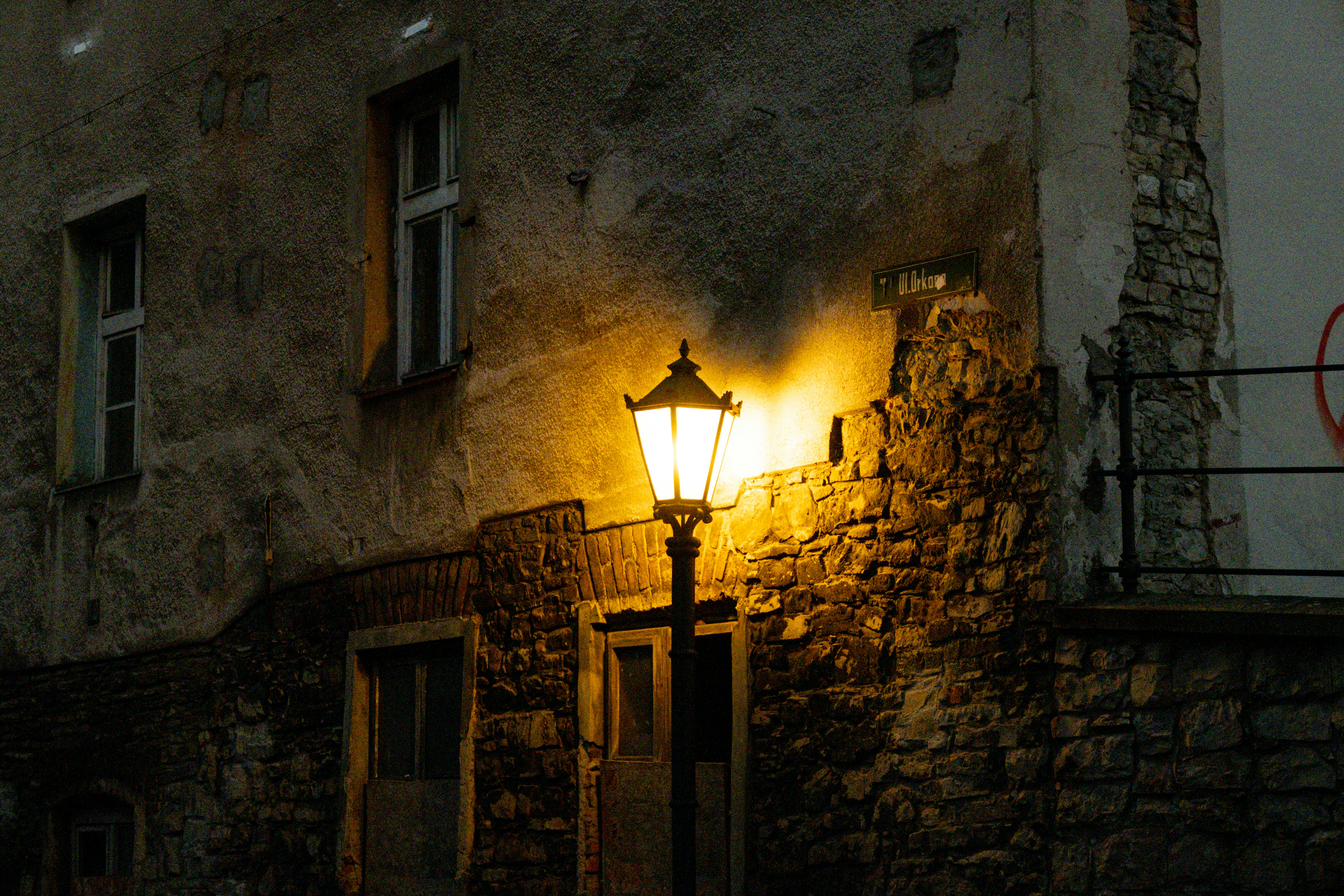 Amber Glow on Weathered Stone: Night Streetlamp Portrait