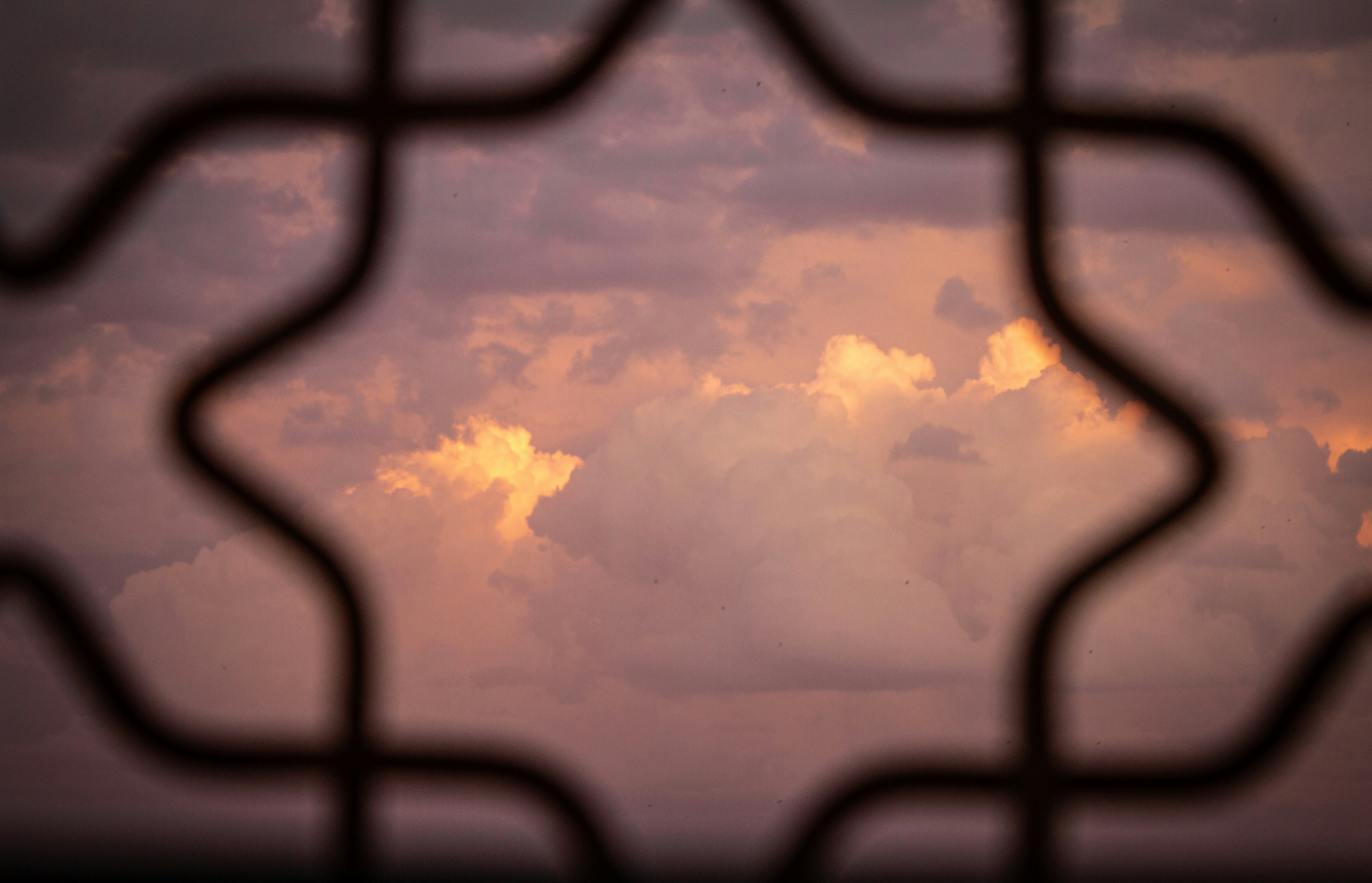 Through the Lattice: Cloudscapes Framed by Wrought Iron
