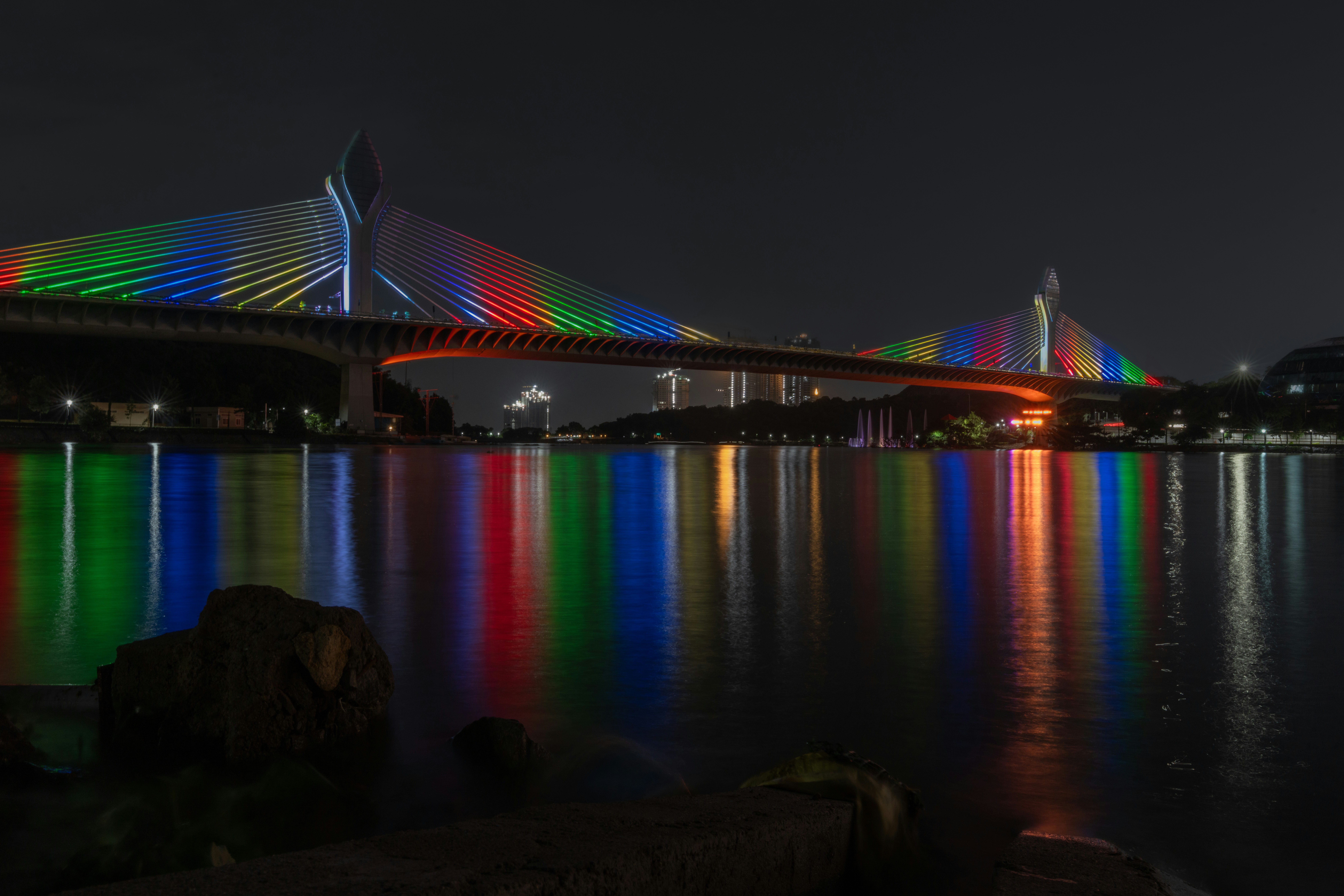 Prismatic River Arc: A Rainbow Bridge at Night